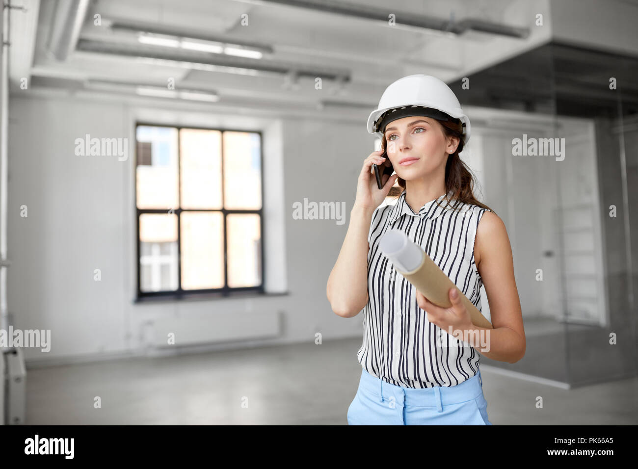 architect with blueprint calling on cell at office Stock Photo - Alamy