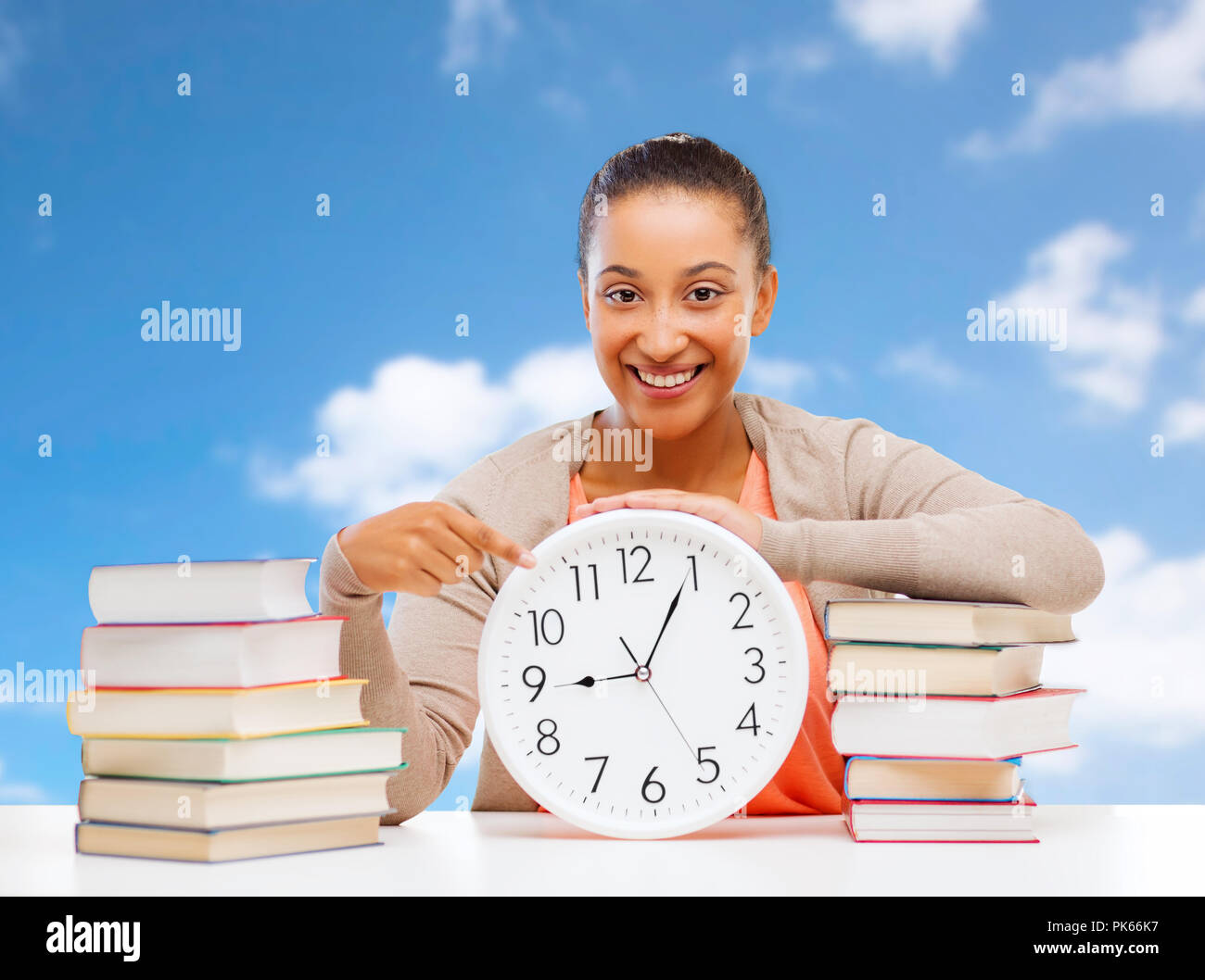 student girl with books showing time on clock Stock Photo - Alamy