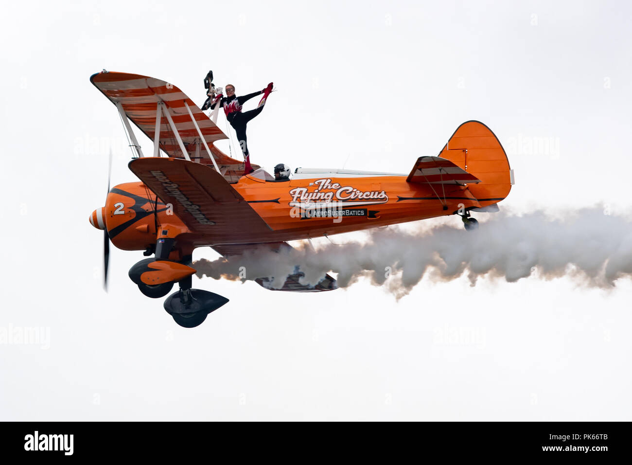 An unharnessed AeroSuperBatics wing walker stands one-legged on the ...