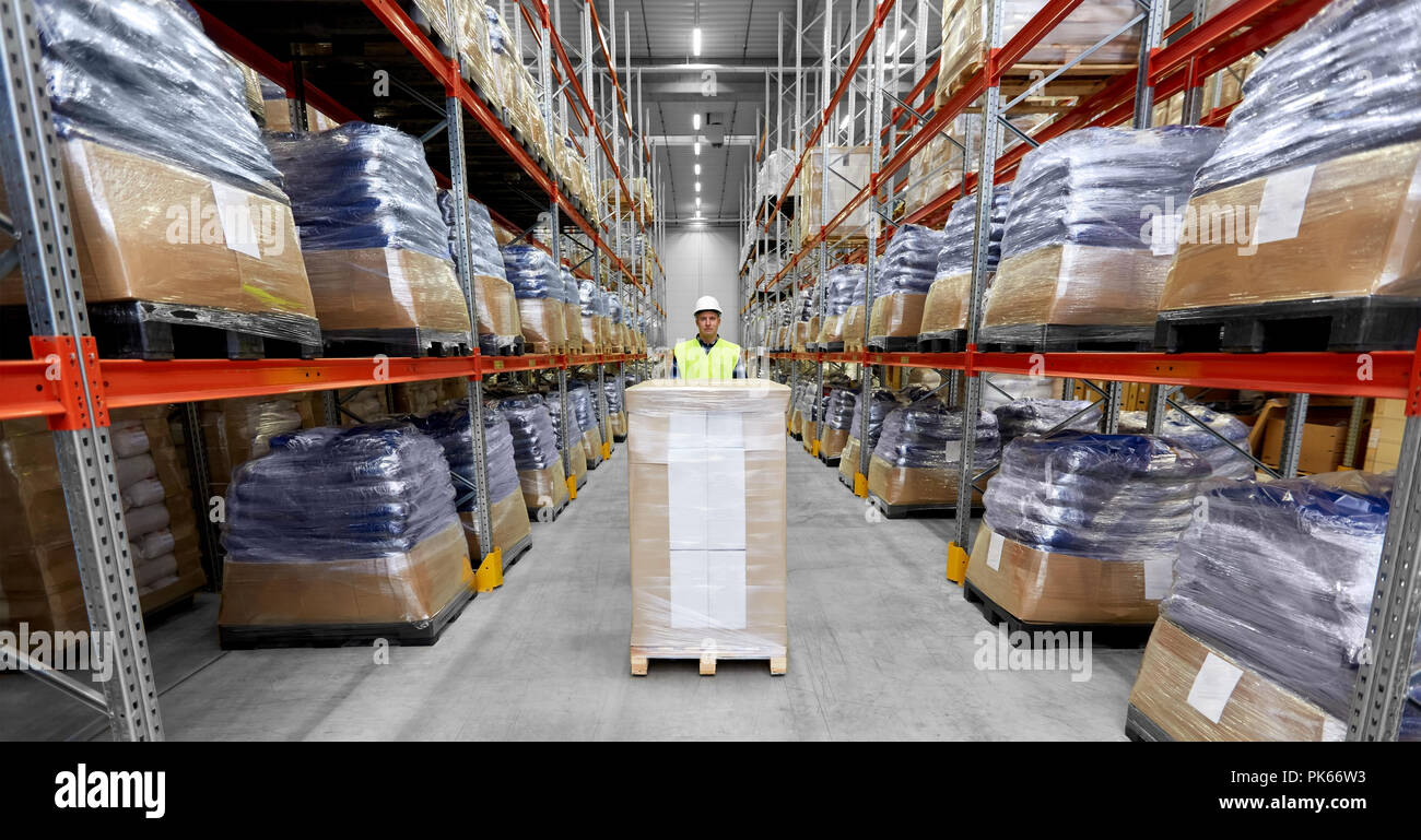 loader in helmet with cargo at warehouse Stock Photo - Alamy