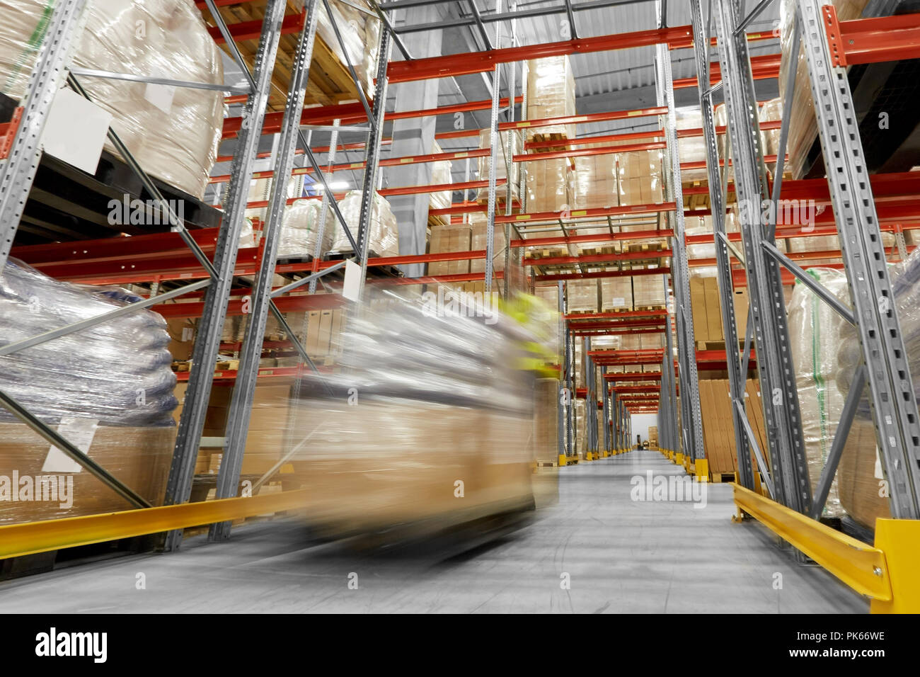 worker carrying loader with goods at warehouse Stock Photo - Alamy