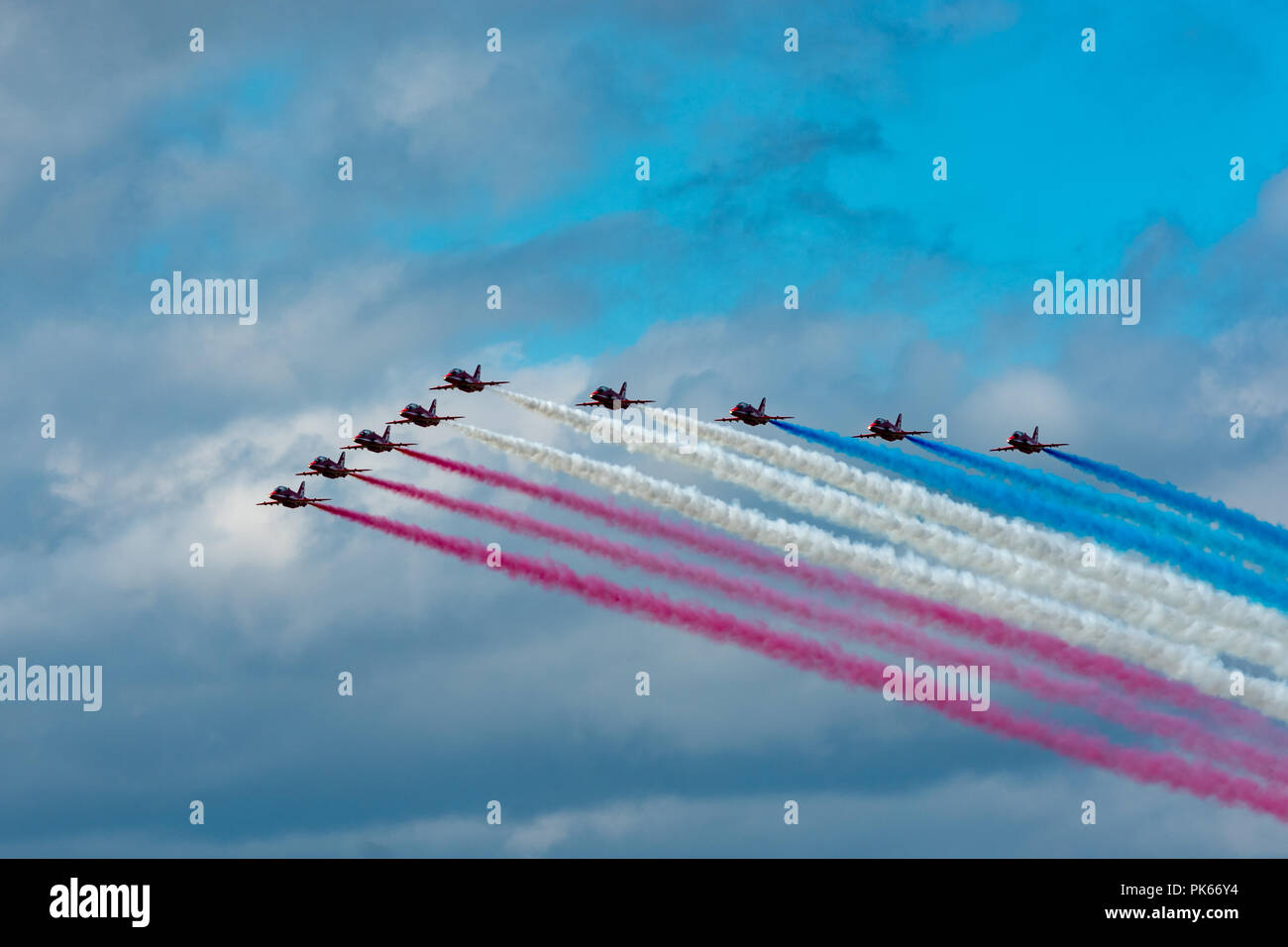Nine Hawk T1 jets of the Red Arrows in full red, white and blue smoke ...