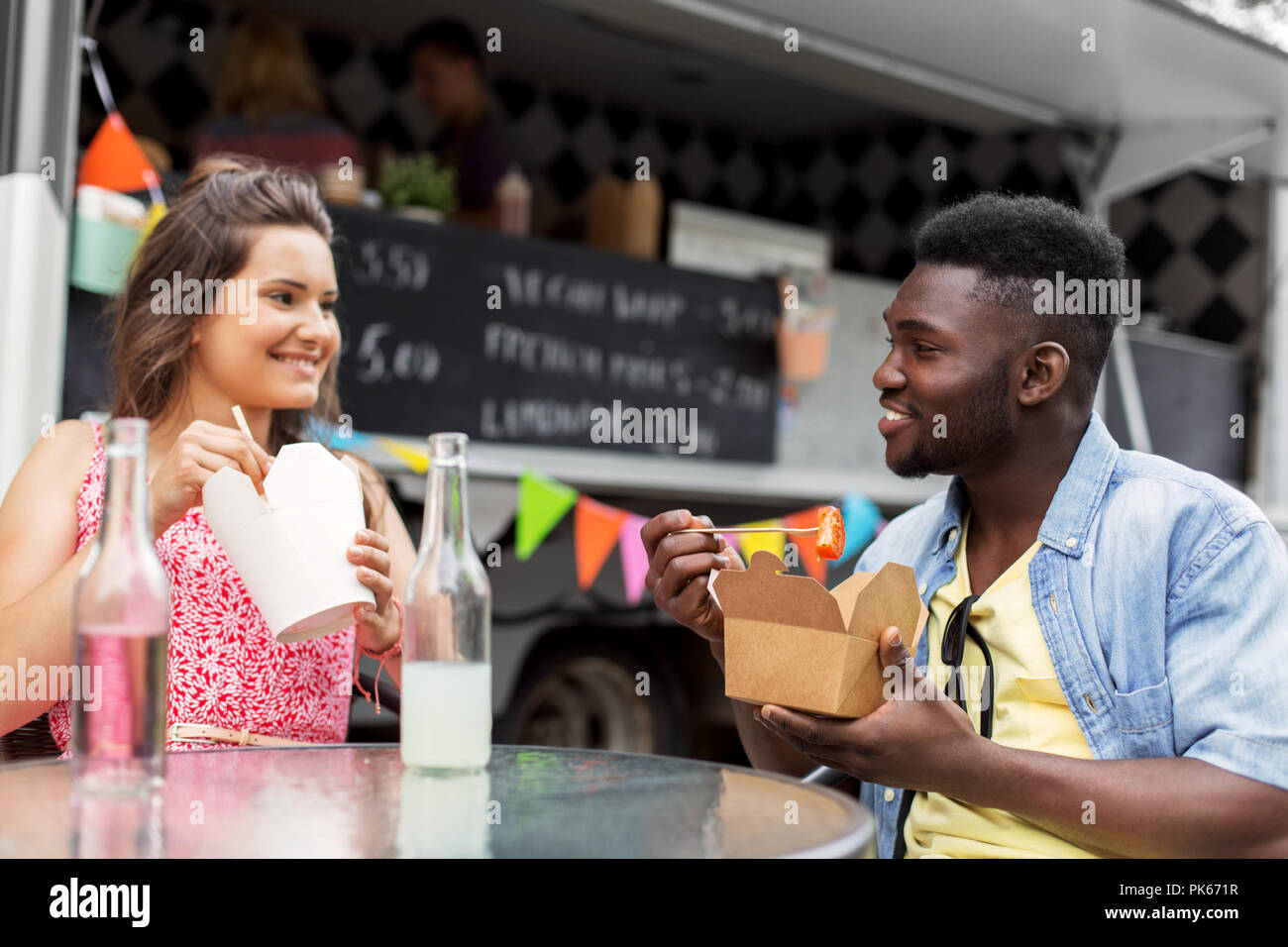mixed race couple eating and talking at food truck Stock Photo - Alamy