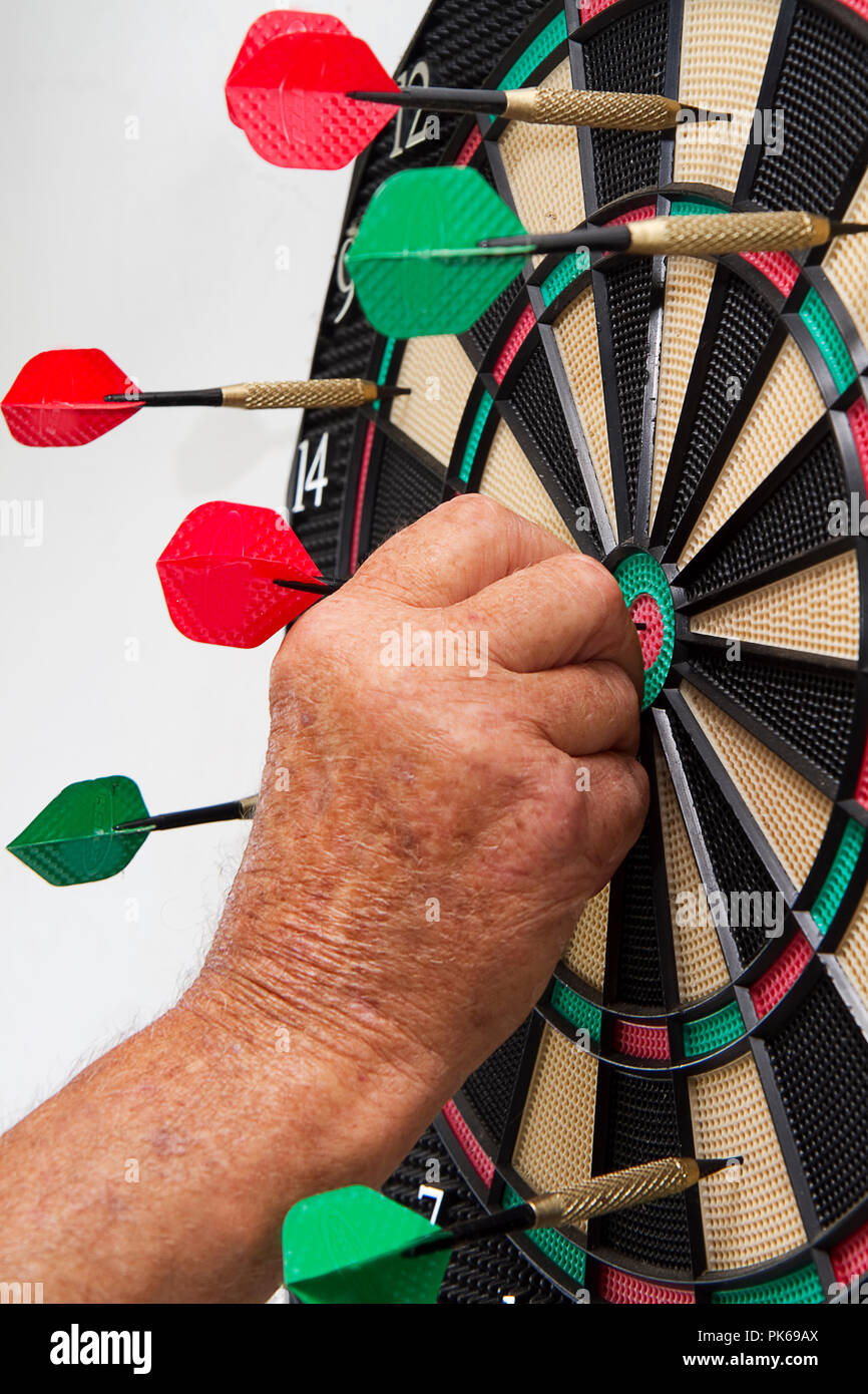 Green and Red Darts on Game Dart Board being pulled off by a man Stock ...
