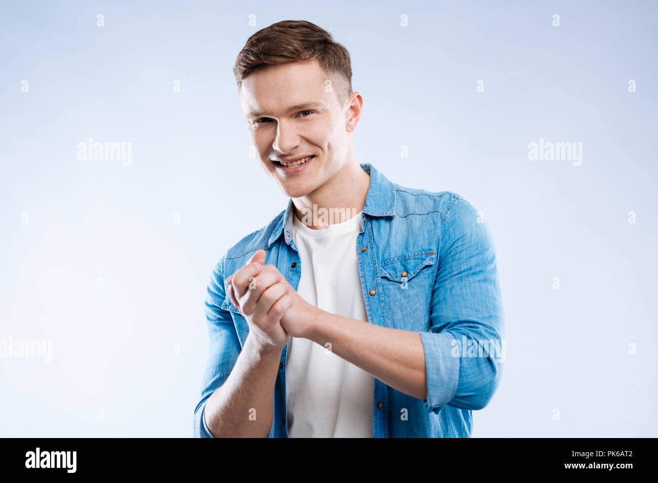 Nice positive man holding his hands together Stock Photo - Alamy
