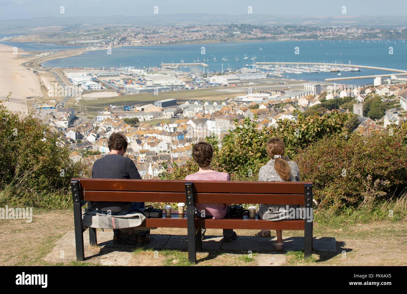 Three people sitting bench hi-res stock photography and images - Alamy