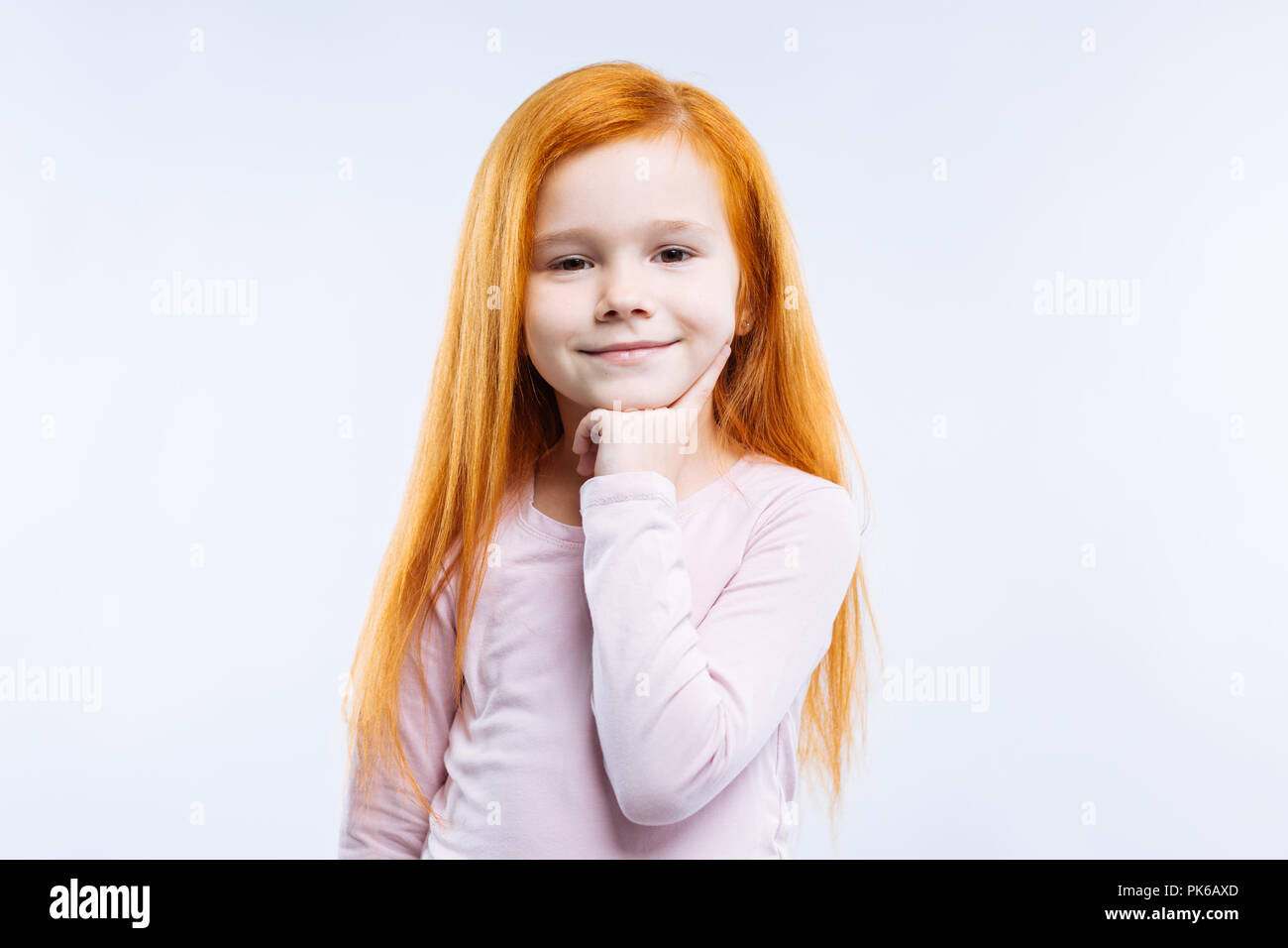 Nice cheerful cute girl touching her chin Stock Photo - Alamy