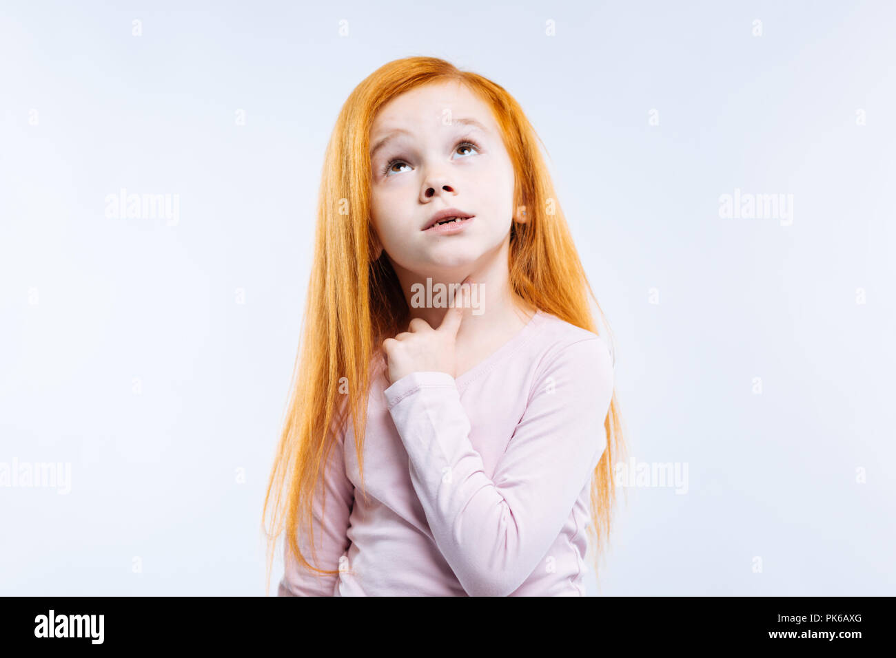 Pleasant thoughtful nice girl touching her neck Stock Photo - Alamy