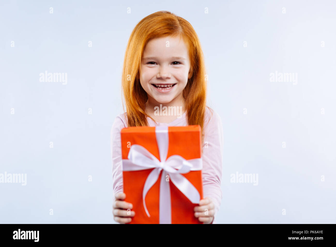 Cheerful kid girl giving gift hi-res stock photography and images - Alamy