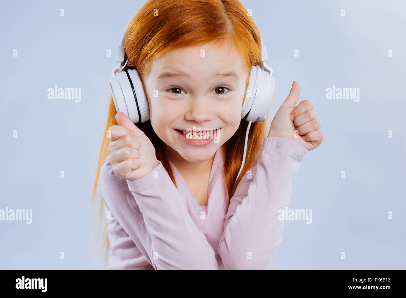 Positive red haired girl listening hi-res stock photography and images ...