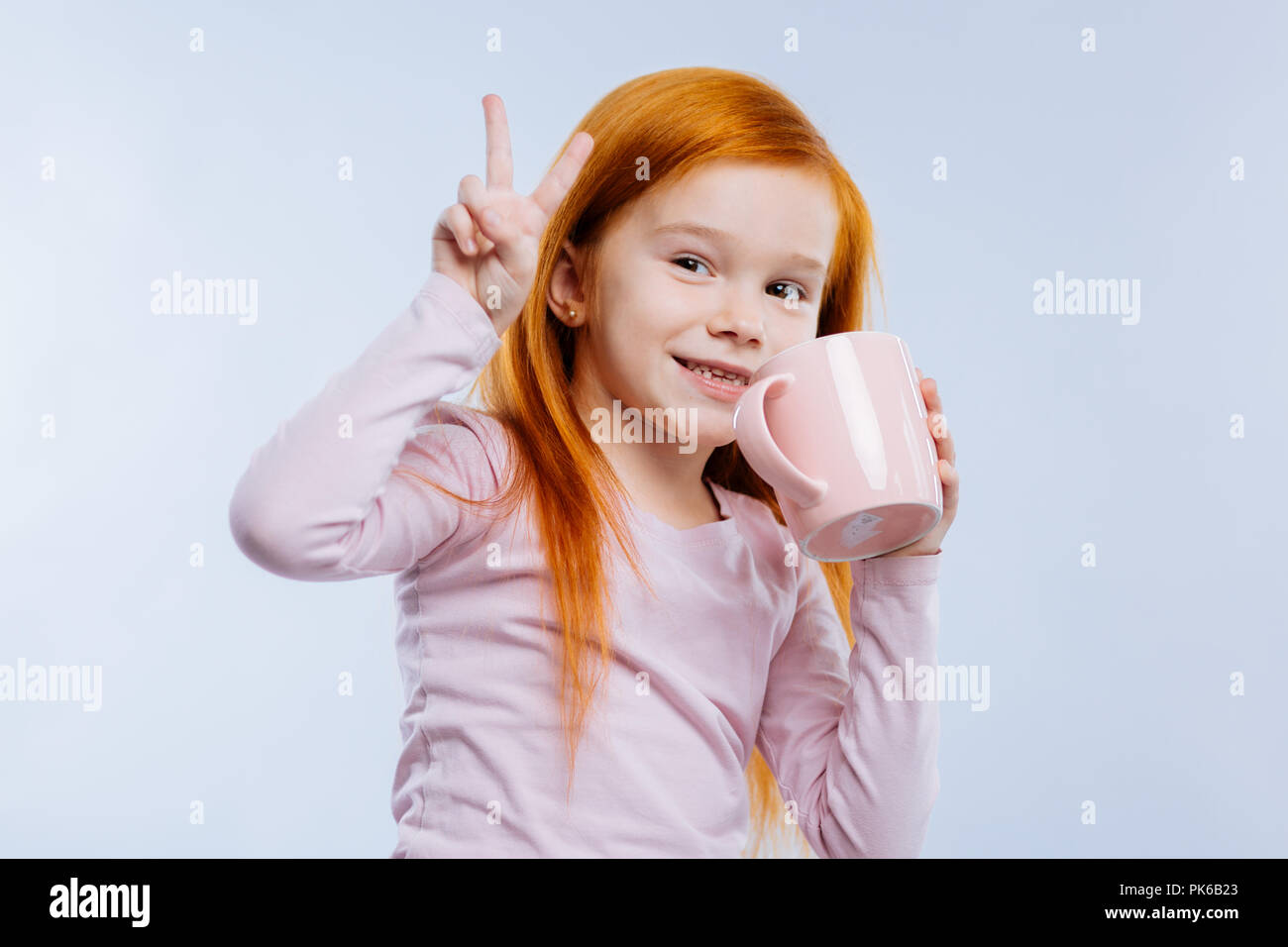 Happy nice girl enjoying her tasty tea Stock Photo - Alamy