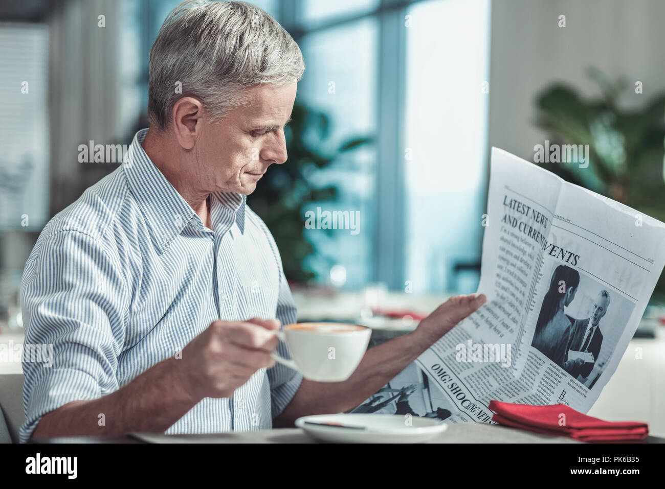 Serious elderly male person reading news in the cafe Stock Photo - Alamy