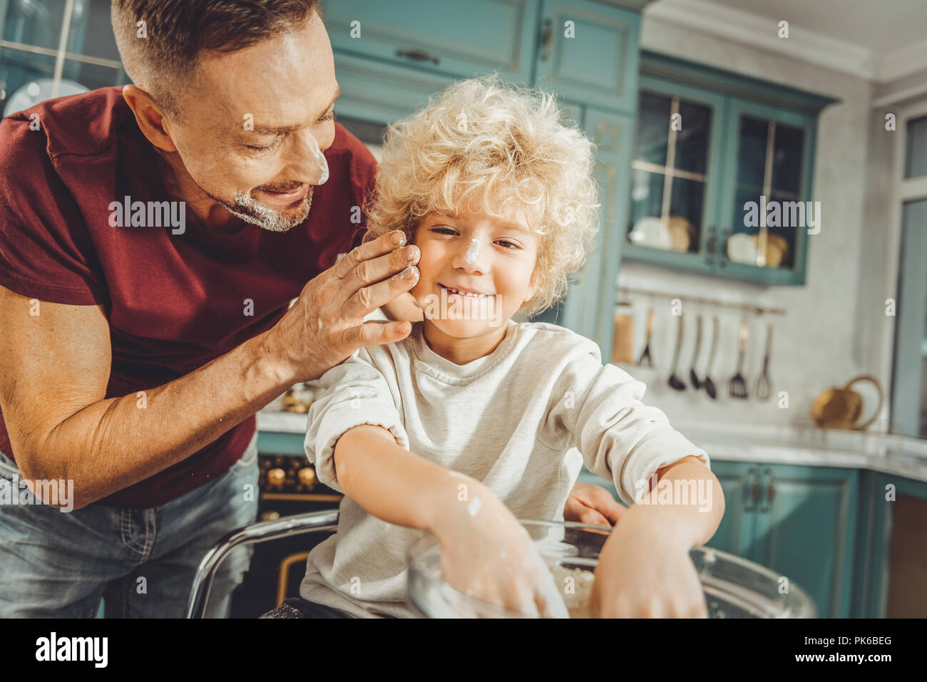 Caring father looking at son while baking pastry together Stock Photo ...