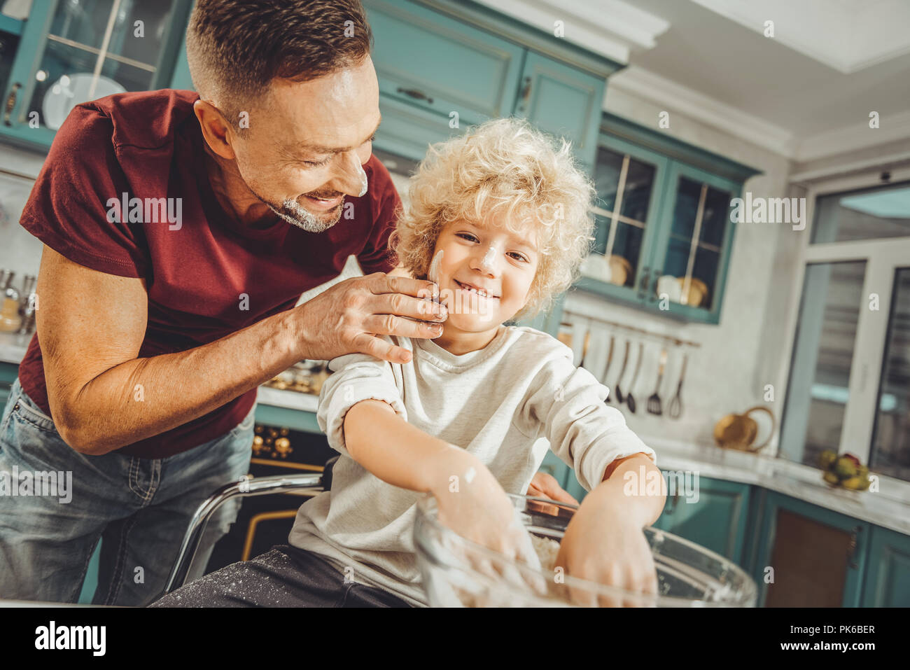 Caring loving father cleaning face of his son baking homemade pie Stock ...