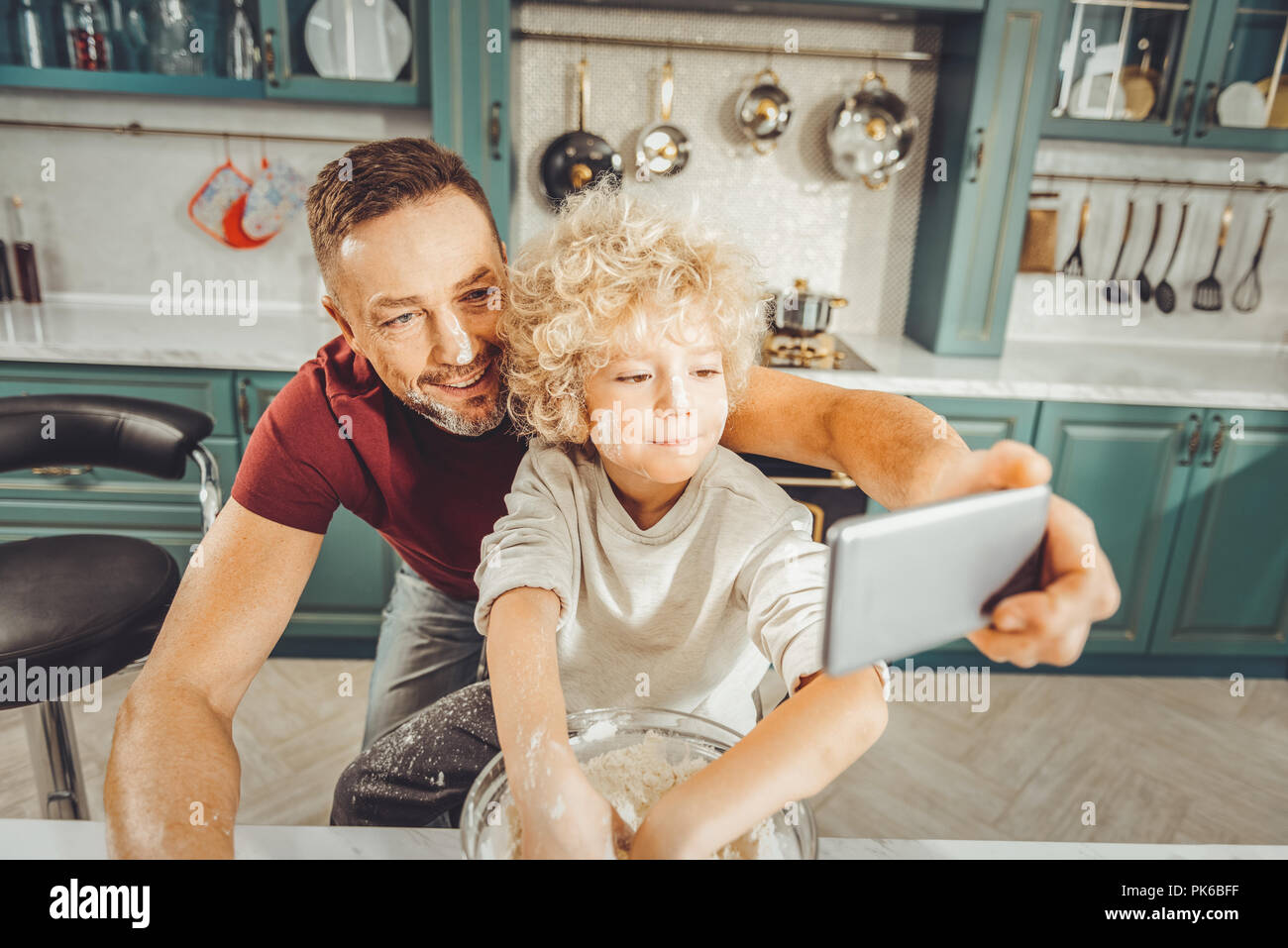 Dark-haired father using his grey phone for making photo with son Stock ...