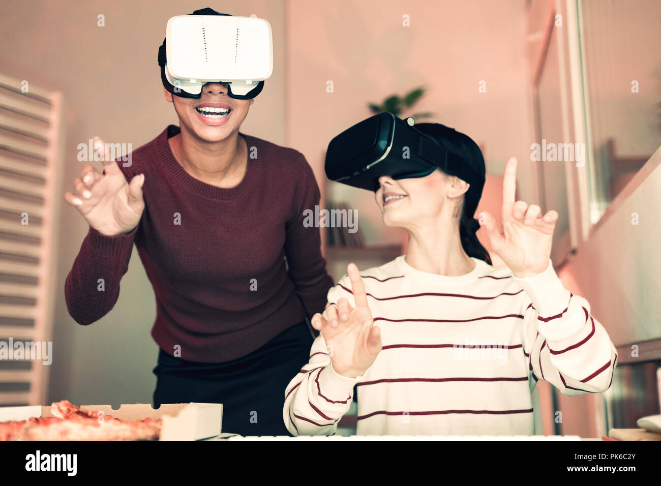 Happy fiends wearing VR glasses together Stock Photo - Alamy