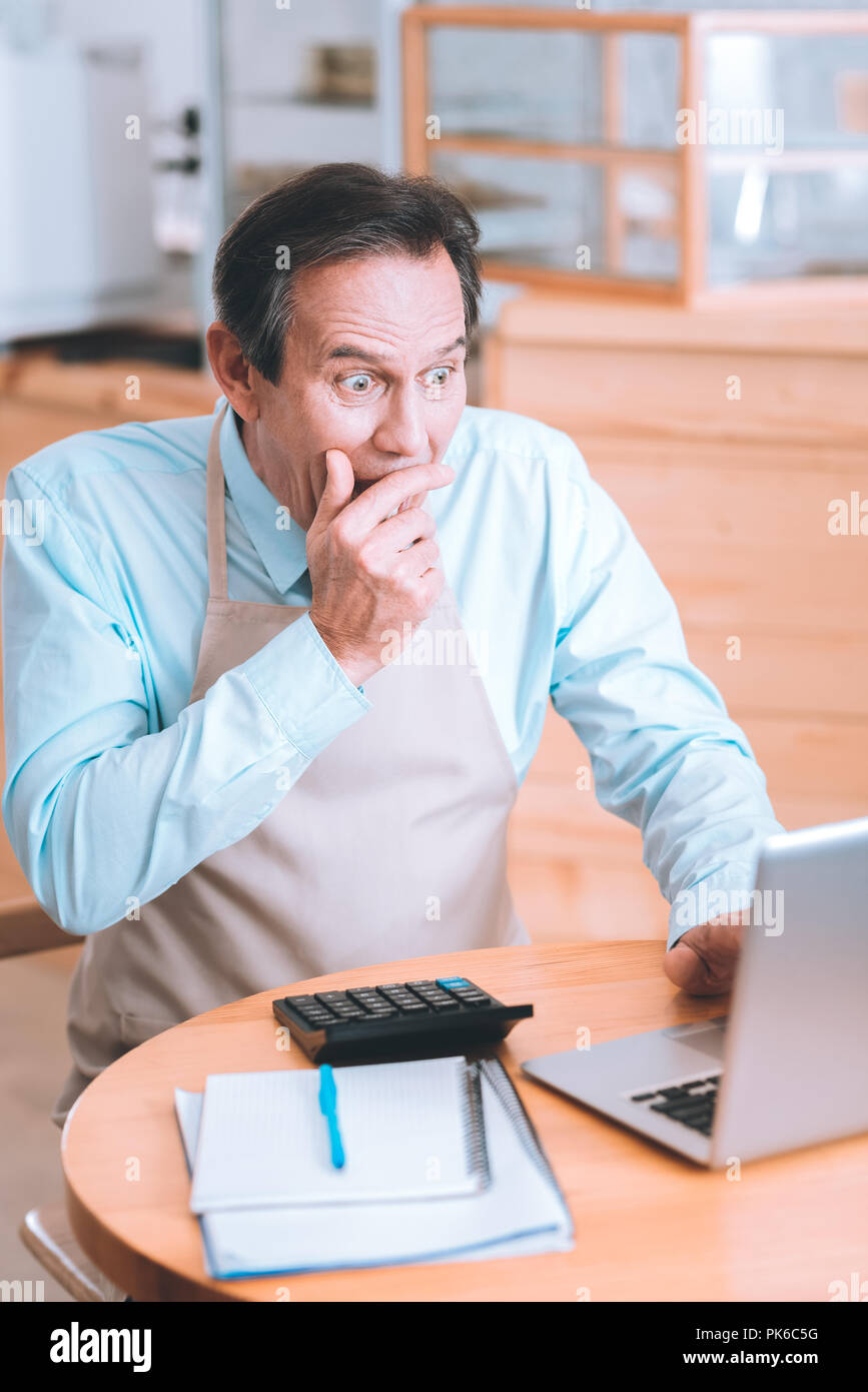 Surprised male person staring at laptop Stock Photo - Alamy