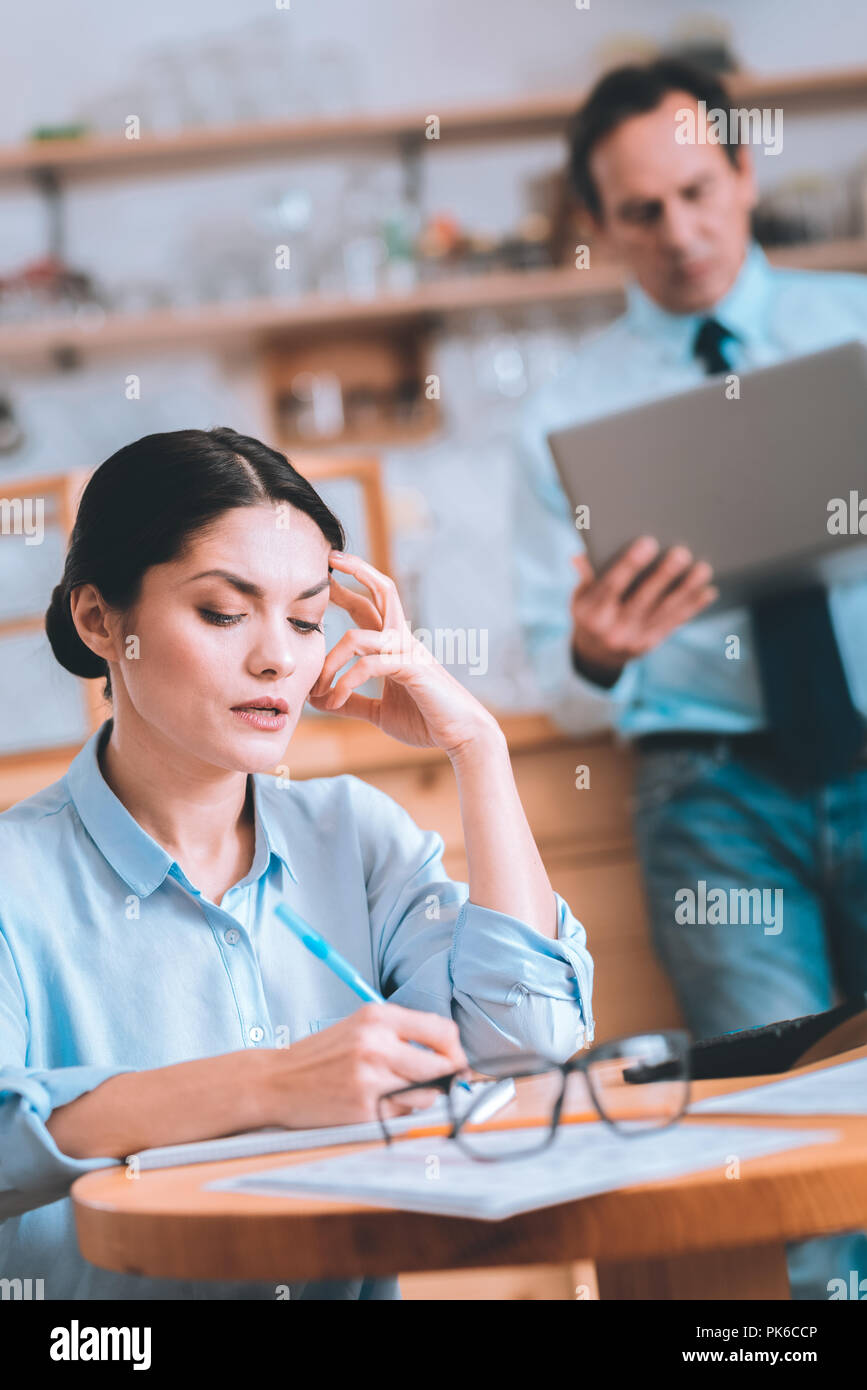 Serious brunette making important notes Stock Photo - Alamy