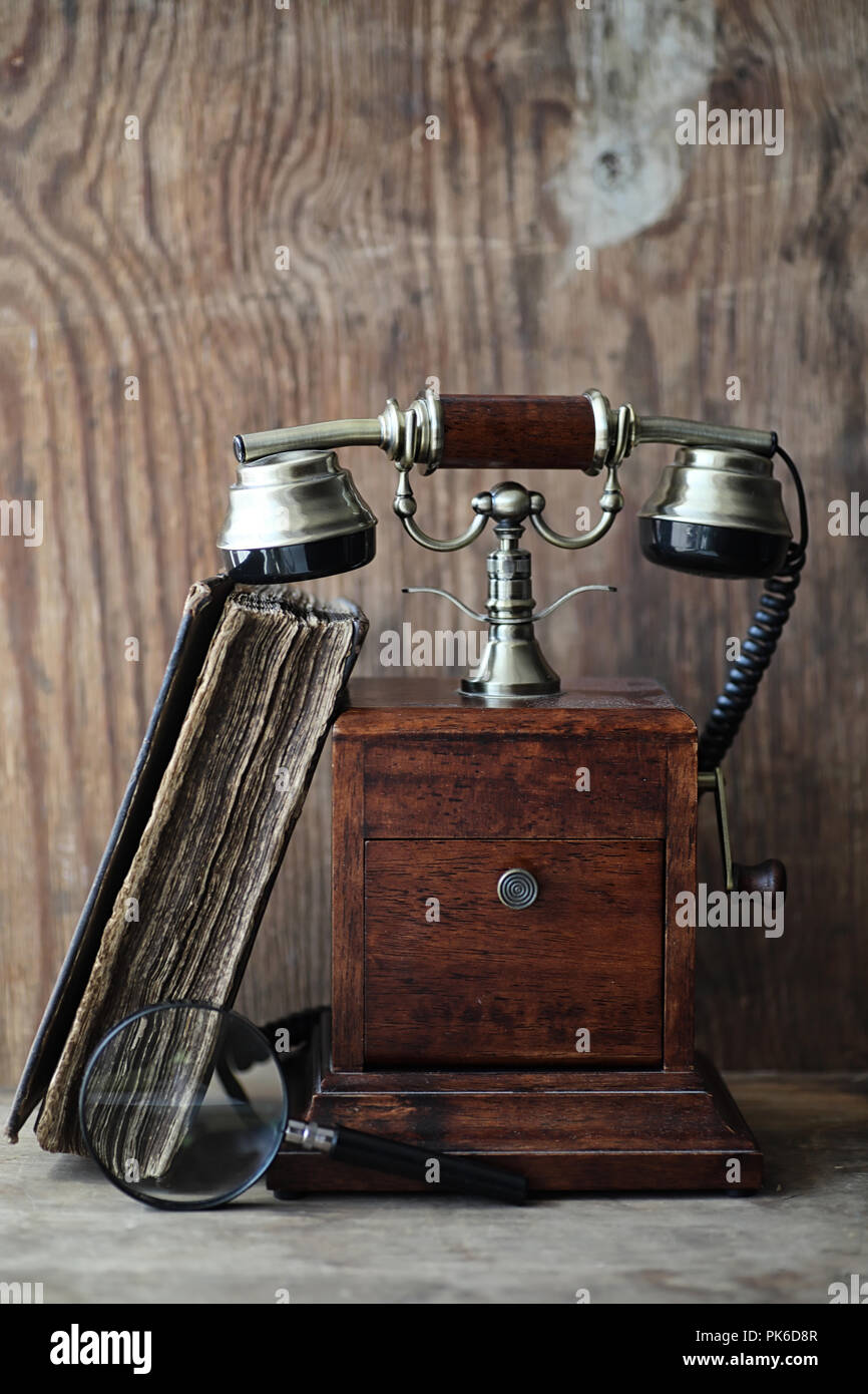 Old telephone and retro book on a wood Stock Photo - Alamy