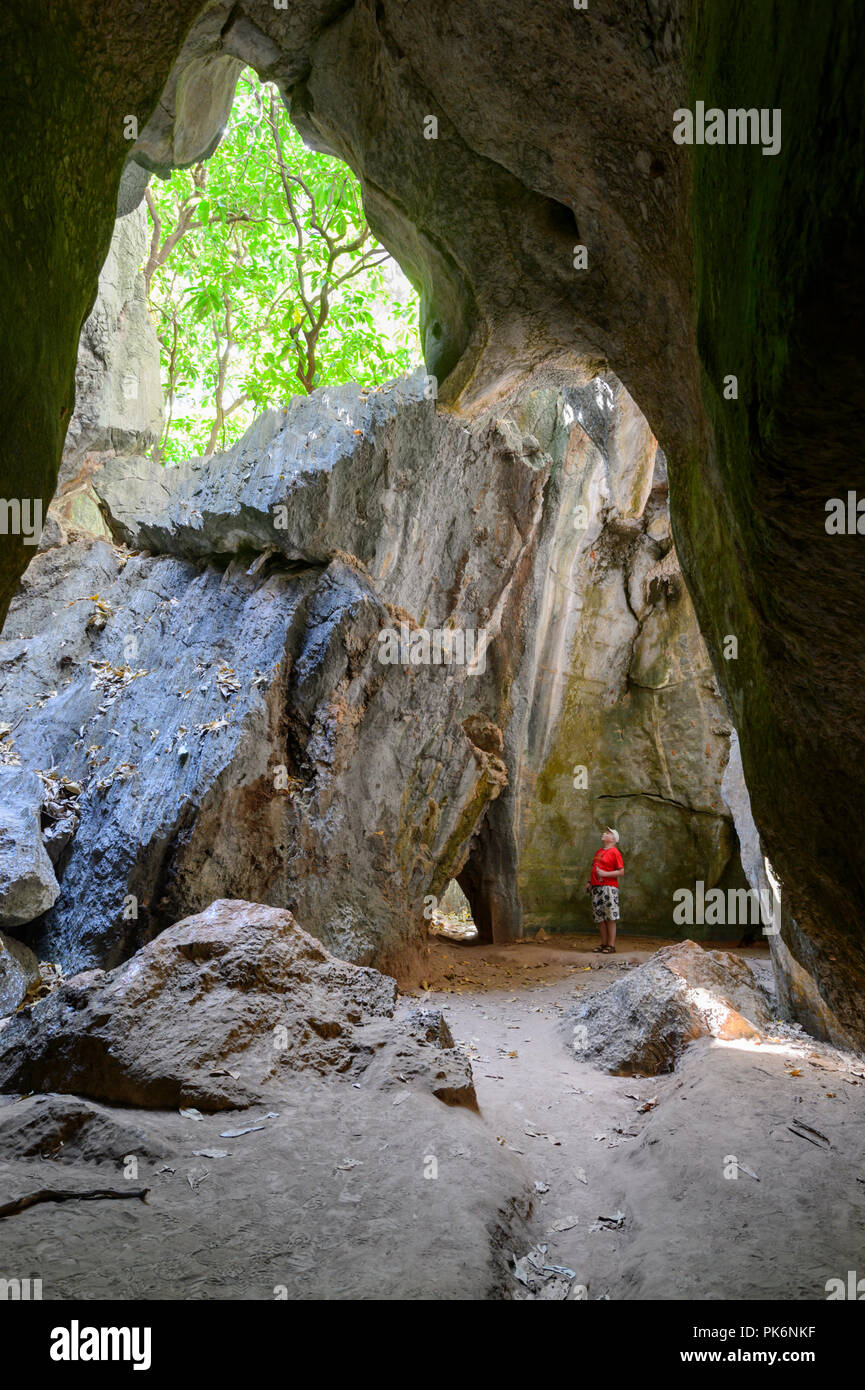 Tourist inspecting a cave at the Archways caves system, Chillagoe ...