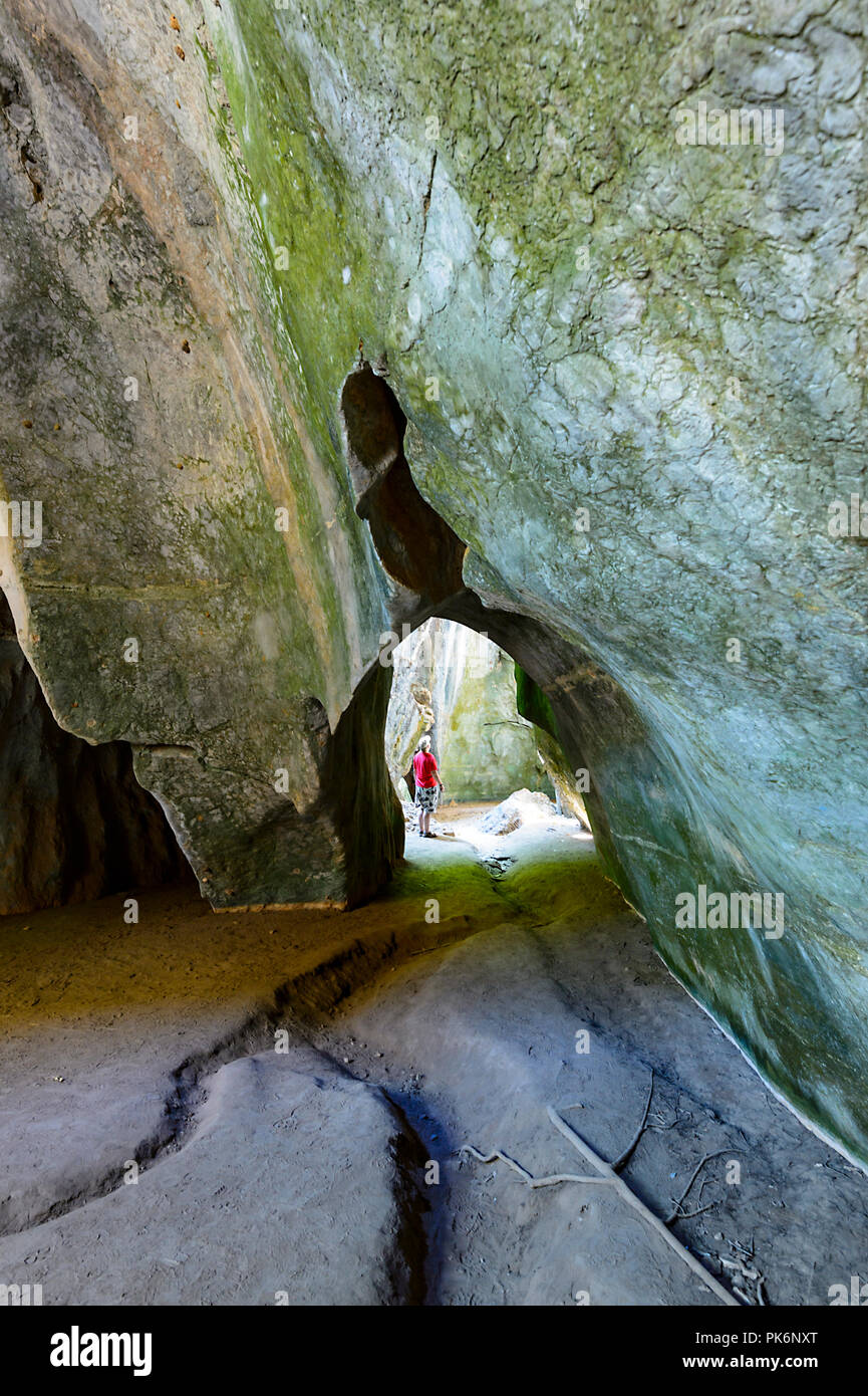 Tourist inspecting a cave at the Archways caves system, Chillagoe ...