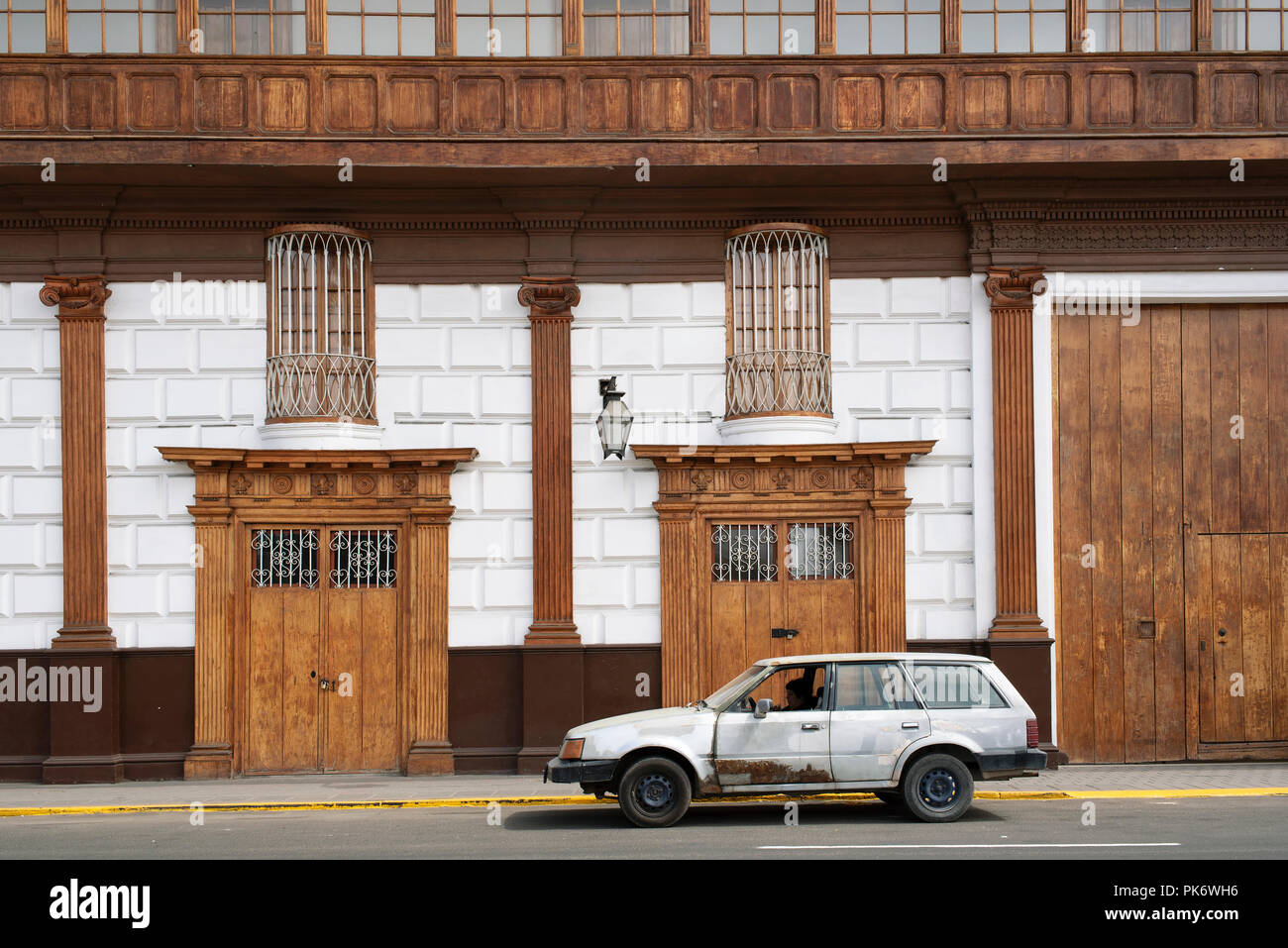 Old, tattered car parking next to a colonial building on Plaza de Armas ...