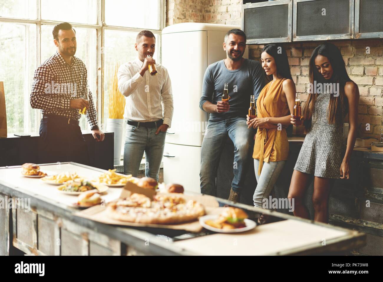 Home party. Full length of cheerful young people enjoying home party ...