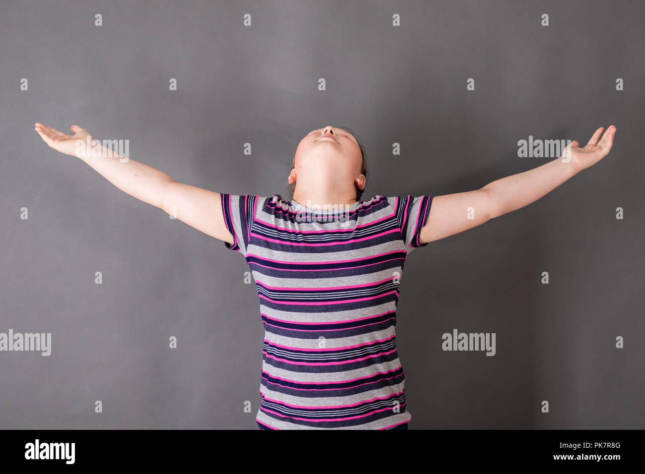 Girl student raising her arms and head upwards Stock Photo - Alamy