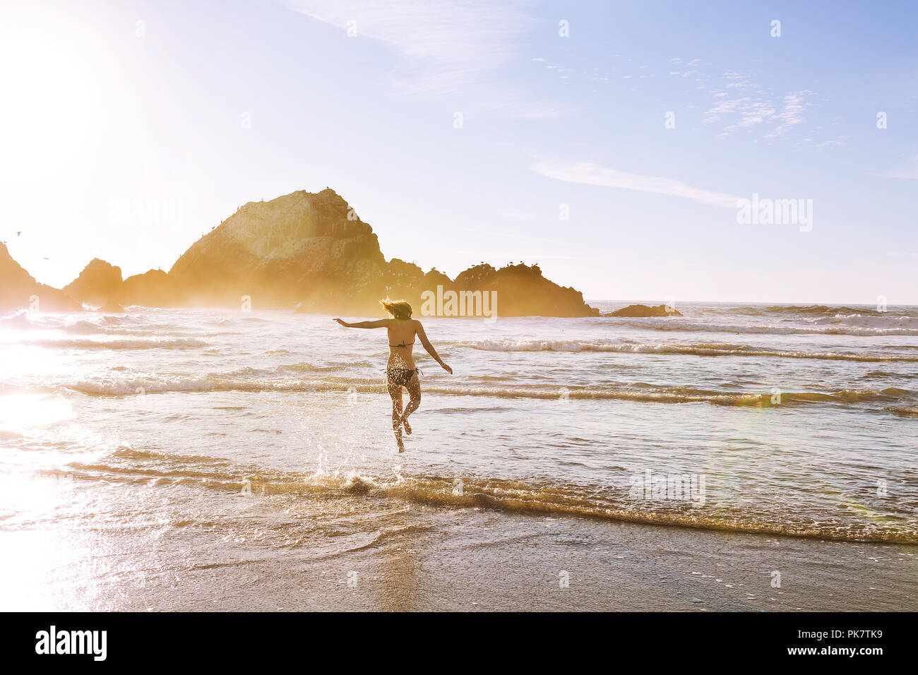 Woman Running into Pacific Ocean Stock Photo - Alamy