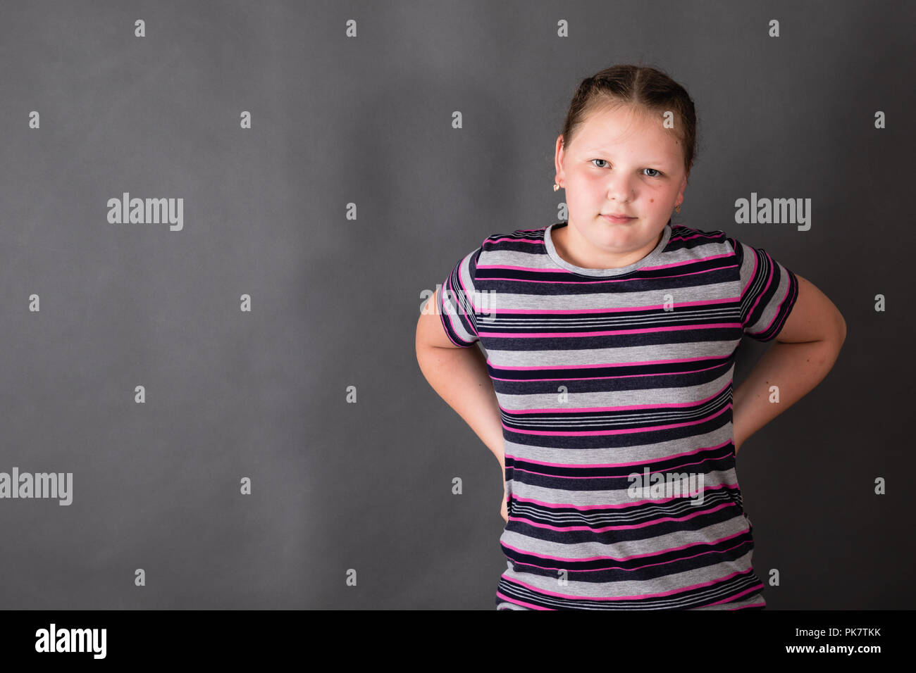 Strong stout girl with arms akimbo Stock Photo - Alamy