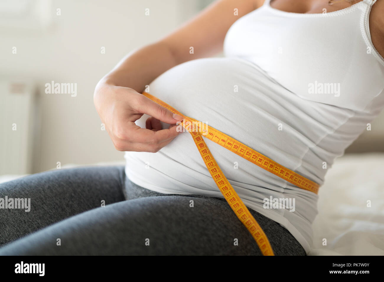 Pregnant woman measuring stomach with measuring tape Stock Photo - Alamy