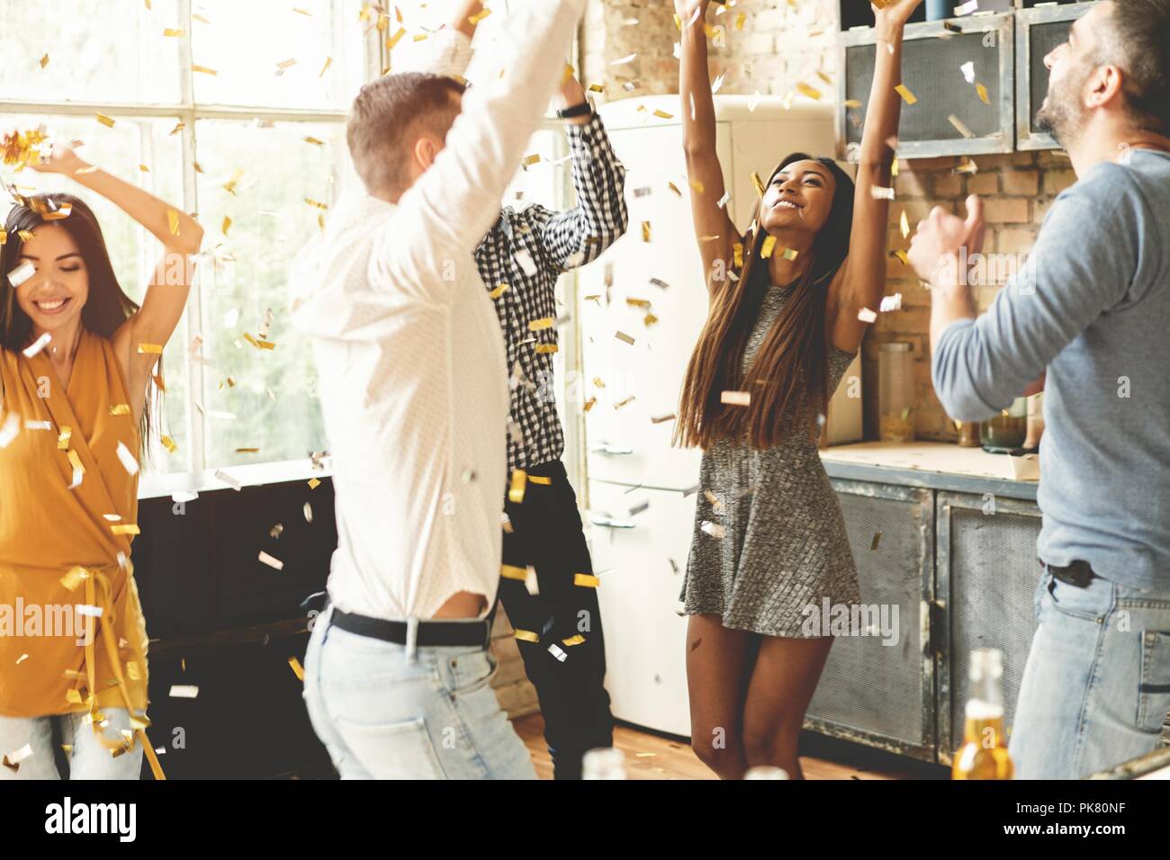 Confetti fun. Group of happy young people throwing confetti and jumping ...