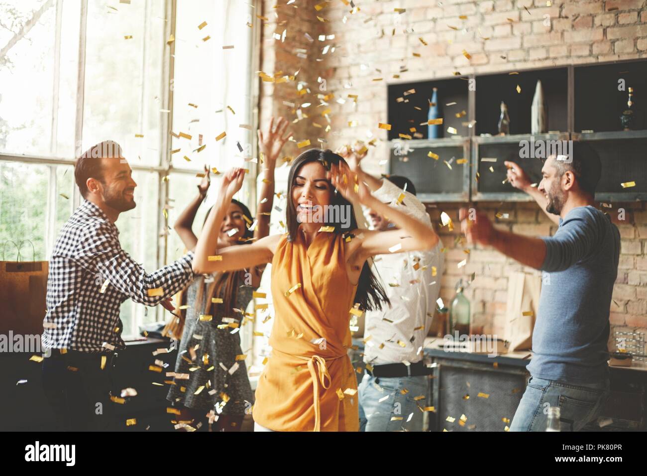 Confetti fun. Group of happy young people throwing confetti and jumping ...