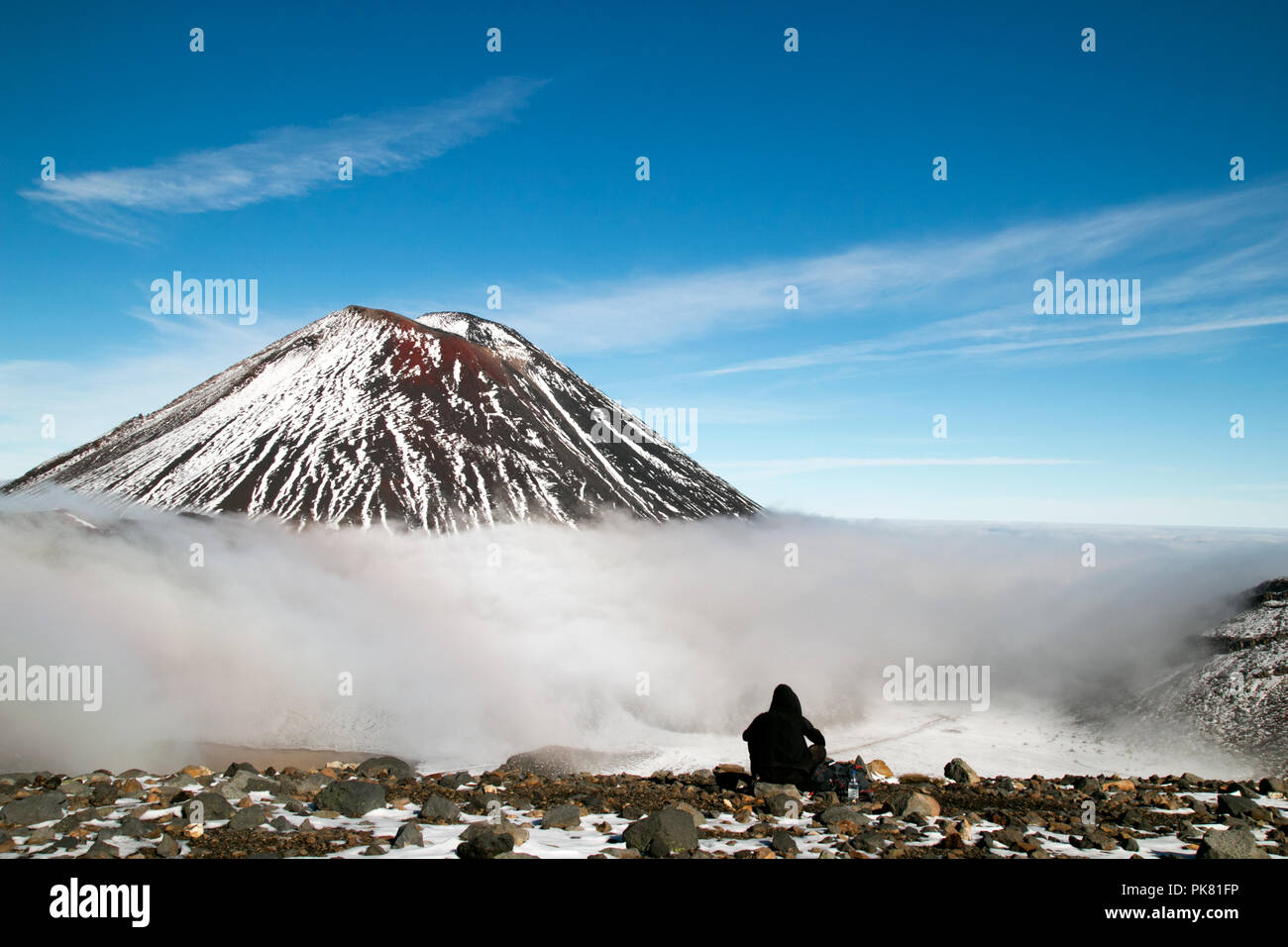 Tramper having rest in front of active volcano, mountain hiker and ...