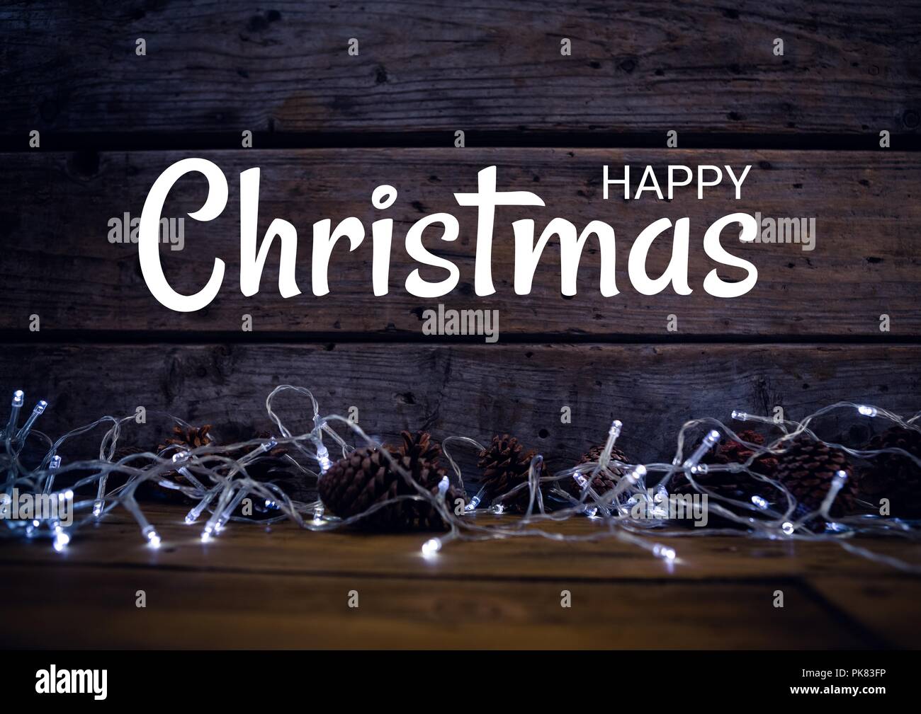 Happy Christmas text with lights on wood Stock Photo - Alamy