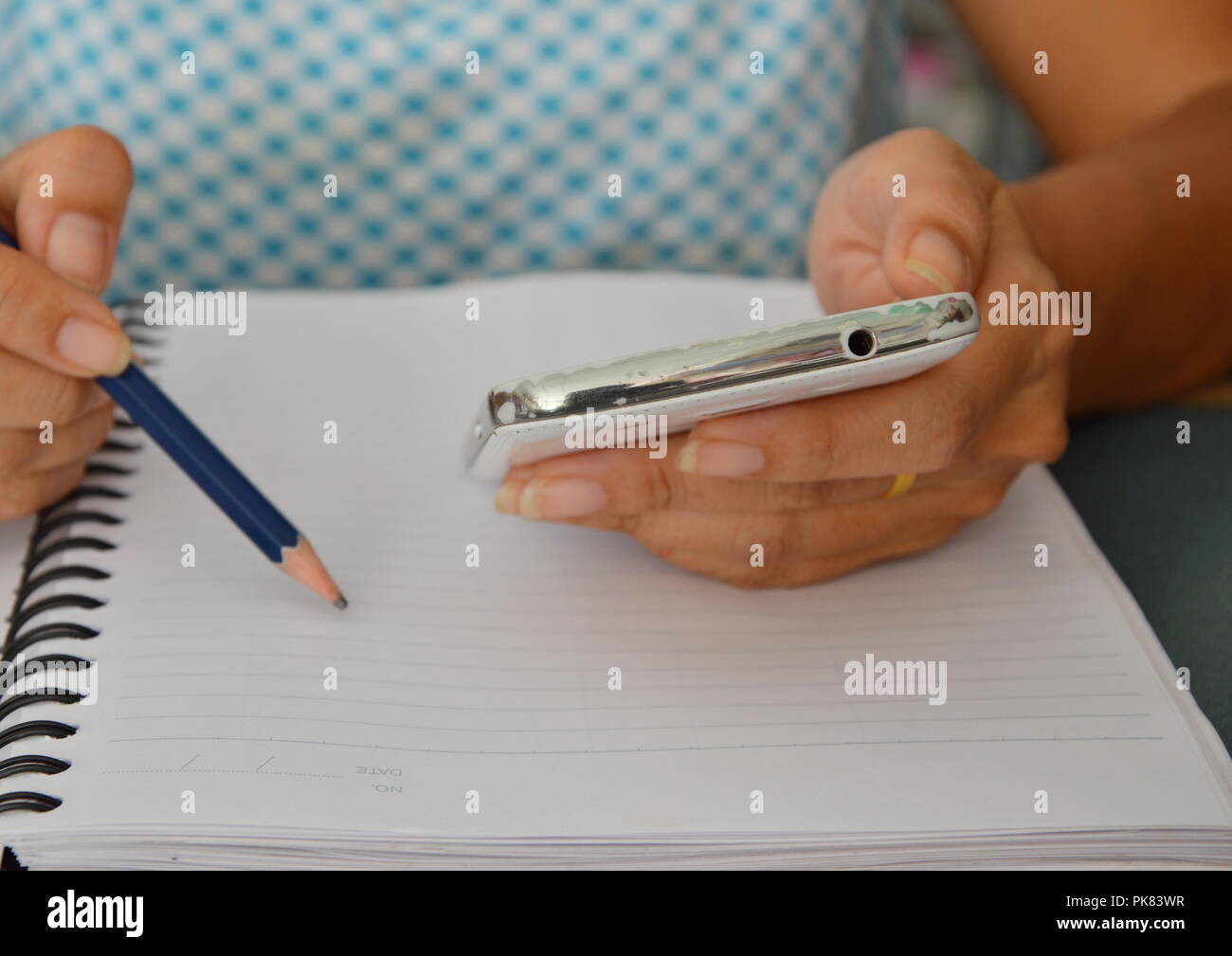 people note information on book from cellphone Stock Photo - Alamy