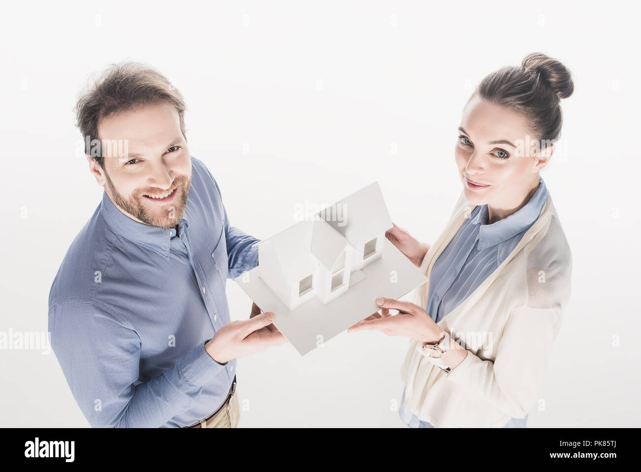 high angle view of married couple holding house model together isolated ...