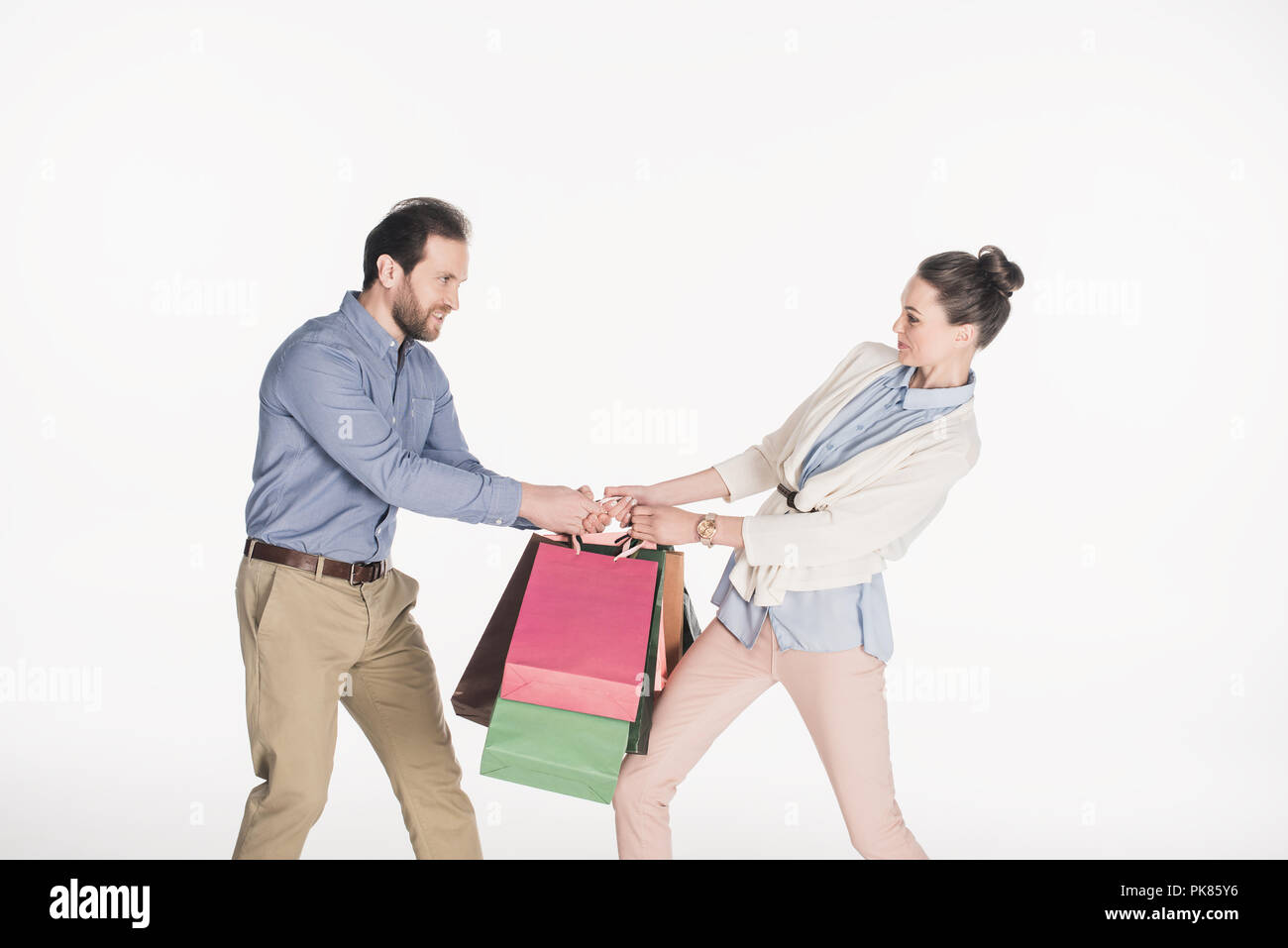 side view of couple pulling over shopping bags isolated on white Stock ...