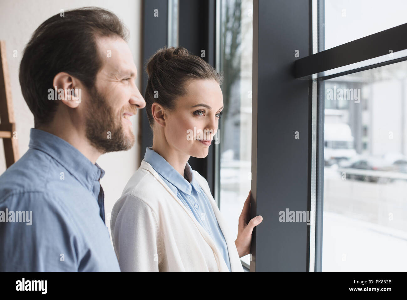 side view of smiling couple looking out window together Stock Photo - Alamy