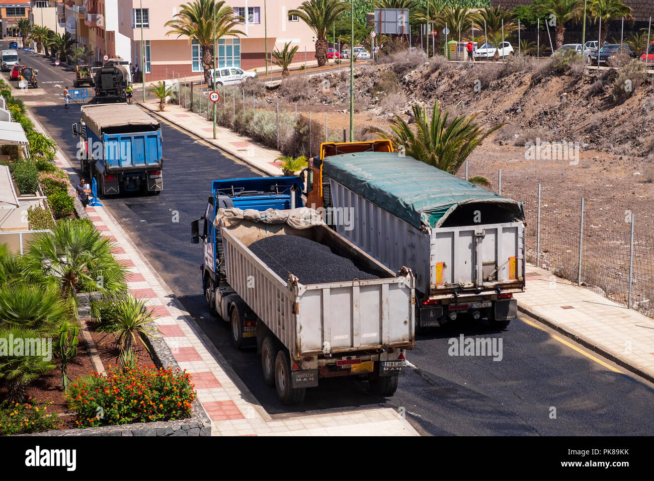 Truckloads of asphalt ready for laying a new layer of tarmac on the ...