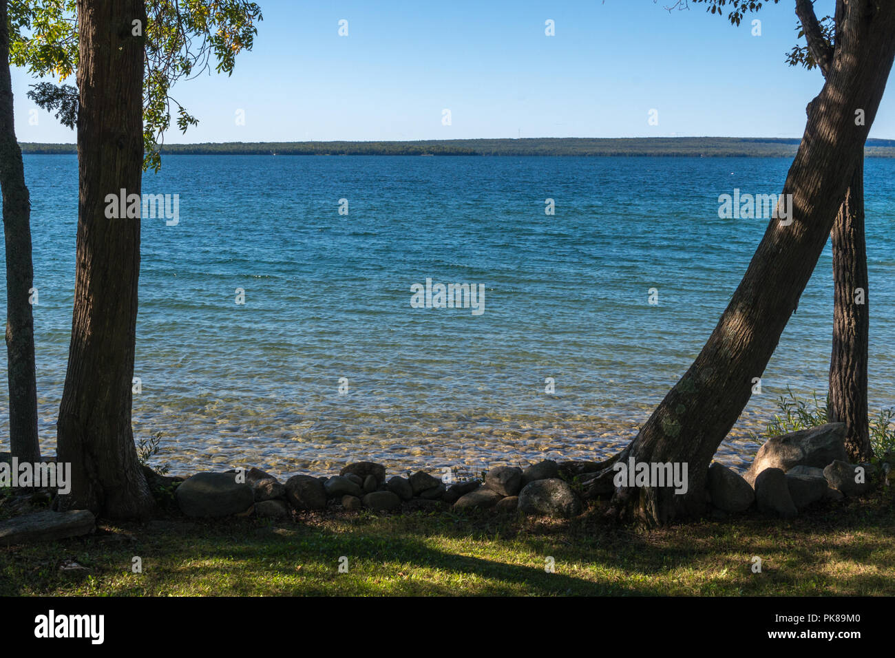 Lake Manitou shoreline landscape with cedar trees and rocks on ...