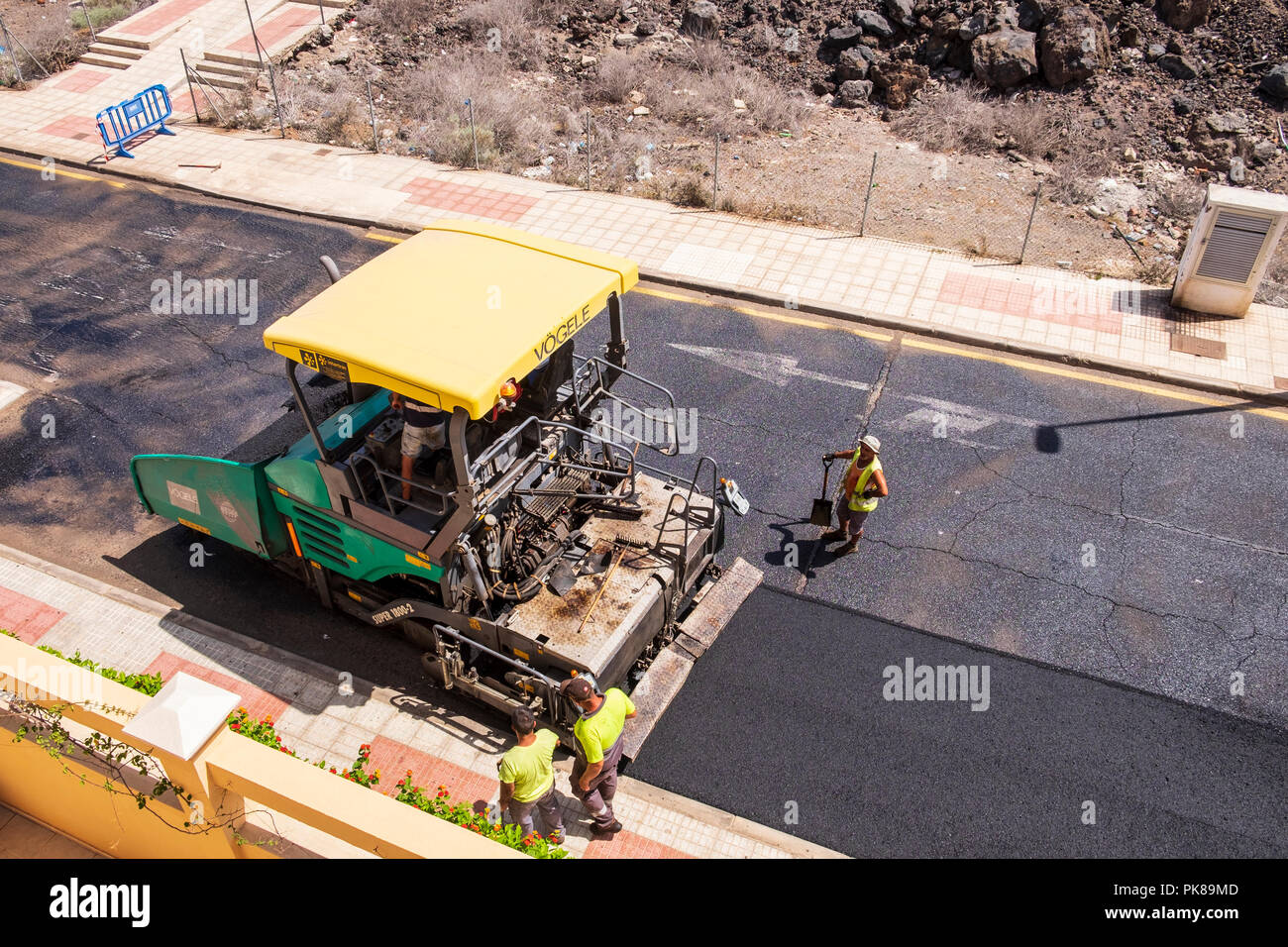 Asphalt spreading machine laying down a new layer of tarmac on the road ...