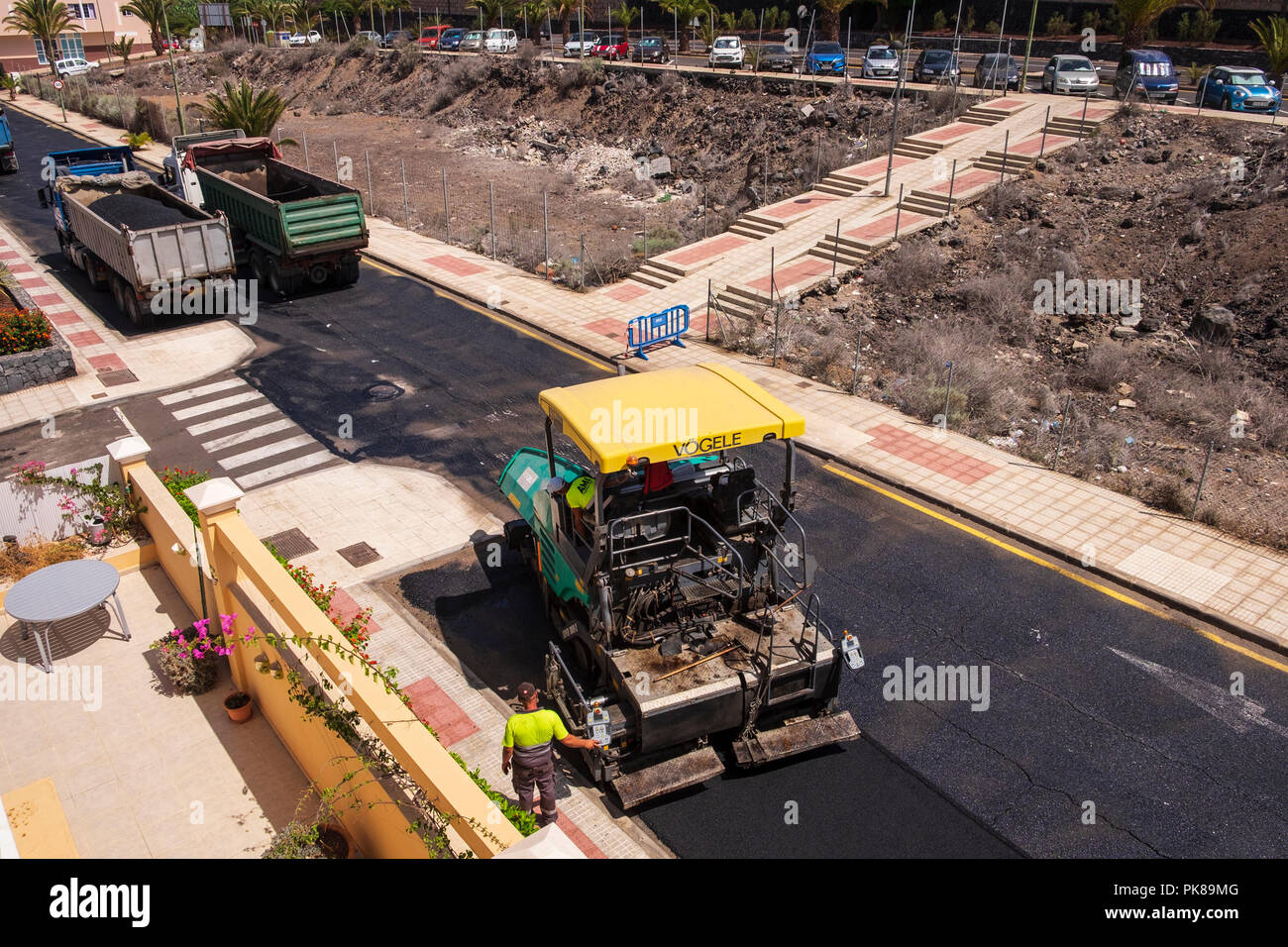 Asphalt spreading machine laying down a new layer of tarmac on the road ...