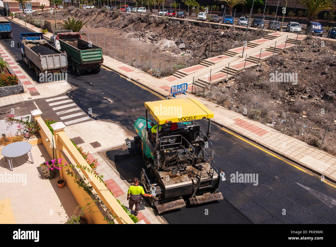 Asphalt spreading machine laying down a new layer of tarmac on the road ...