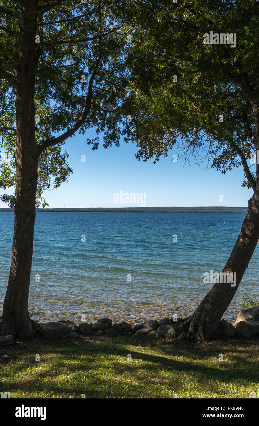 Lake Manitou shoreline landscape with cedar trees and rocks on ...