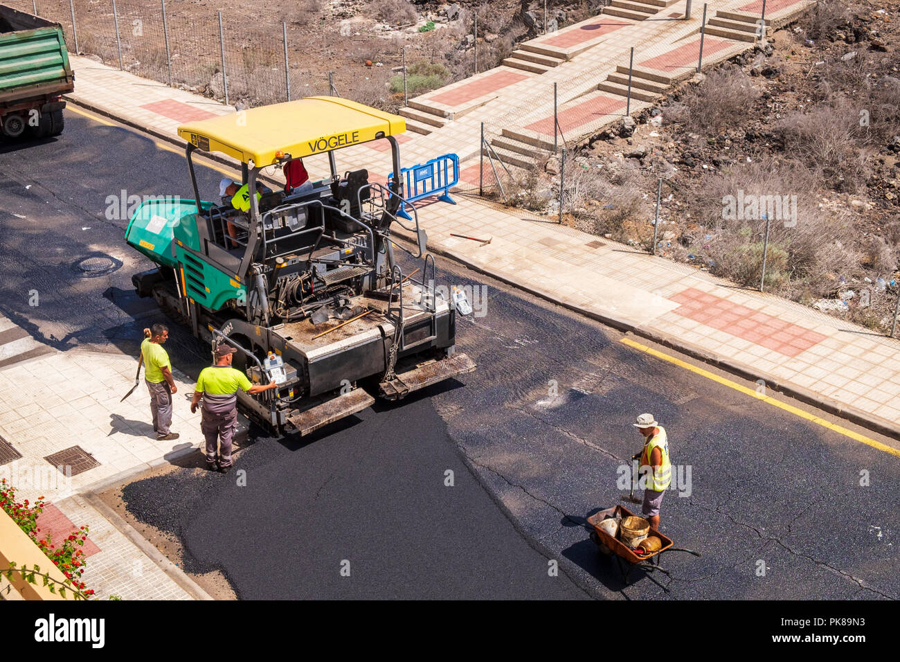 Asphalt spreading machine laying down a new layer of tarmac on the road ...