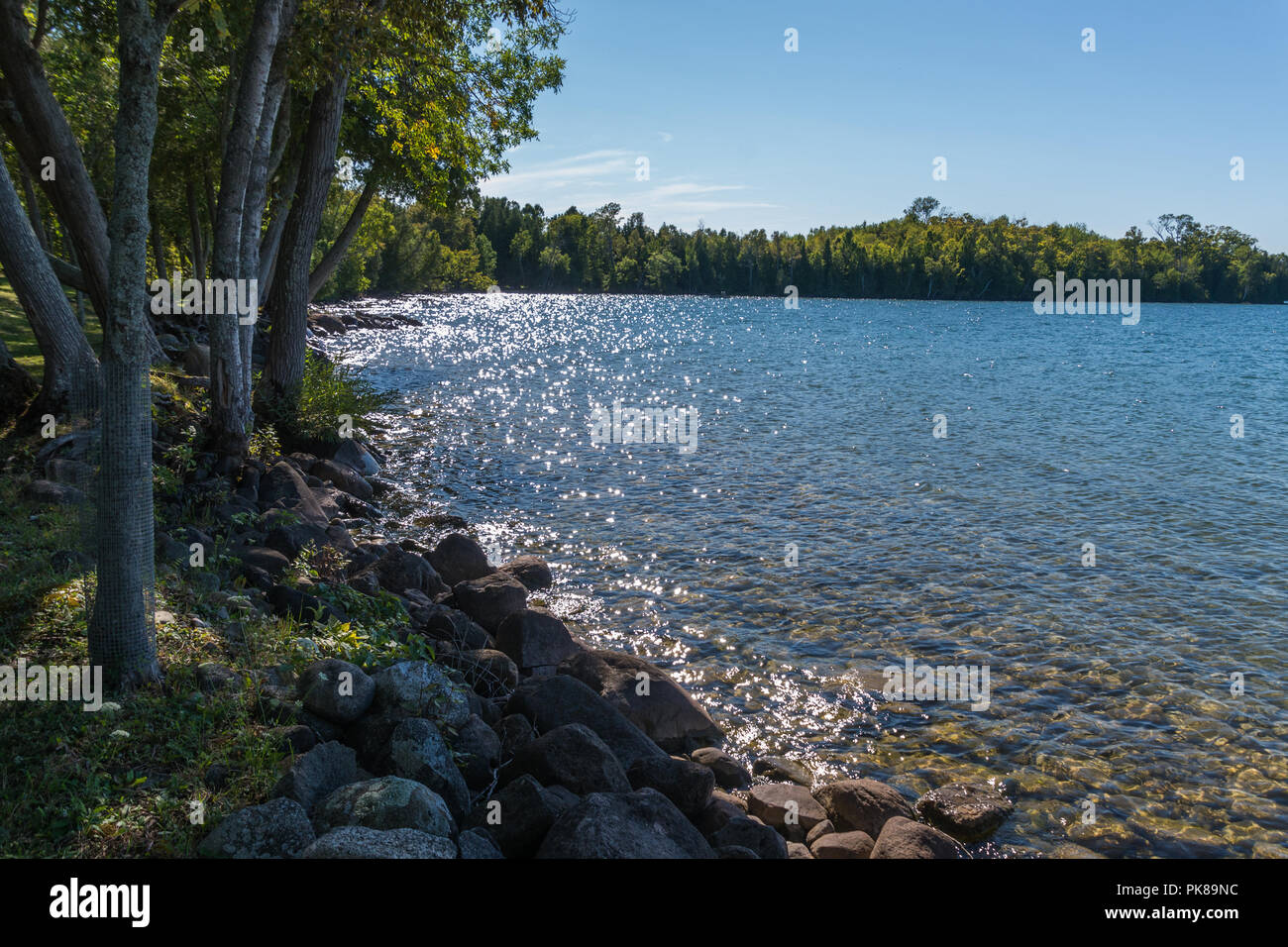 Lake Manitou shoreline landscape with cedar trees and rocks on ...