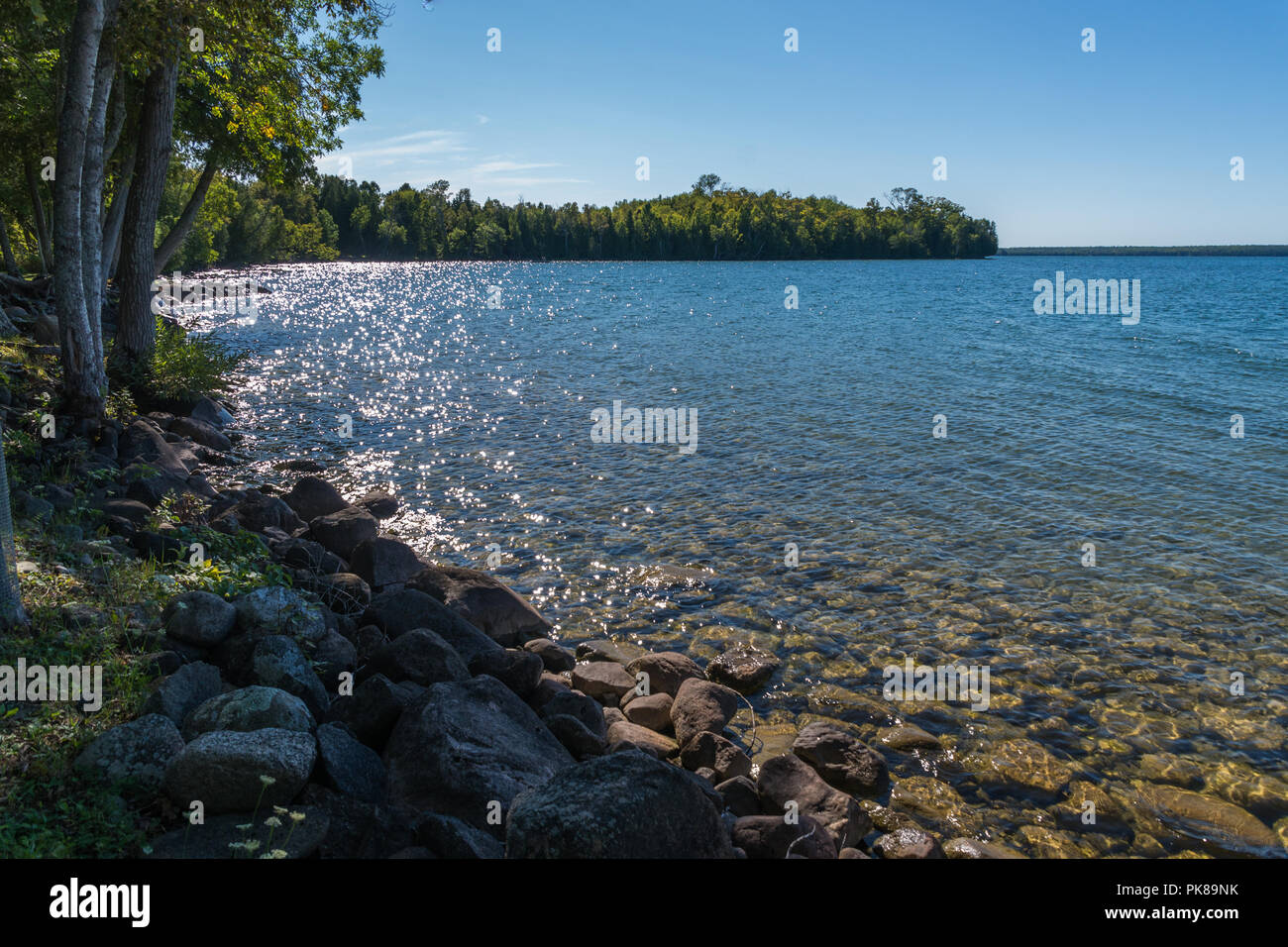 Lake Manitou shoreline landscape with cedar trees and rocks on ...