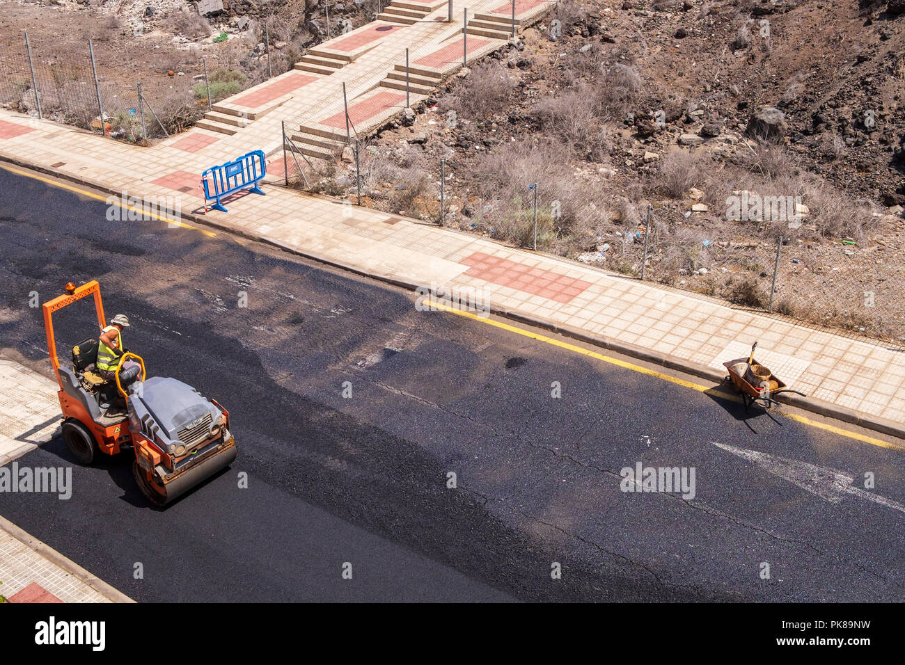 Roller machine smoothing out and compressing a new layer of asphalt ...