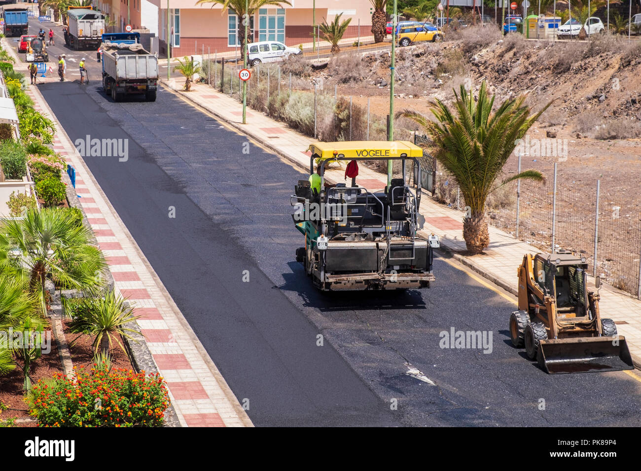 Asphalt spreading machine laying down a new layer of tarmac on the road ...